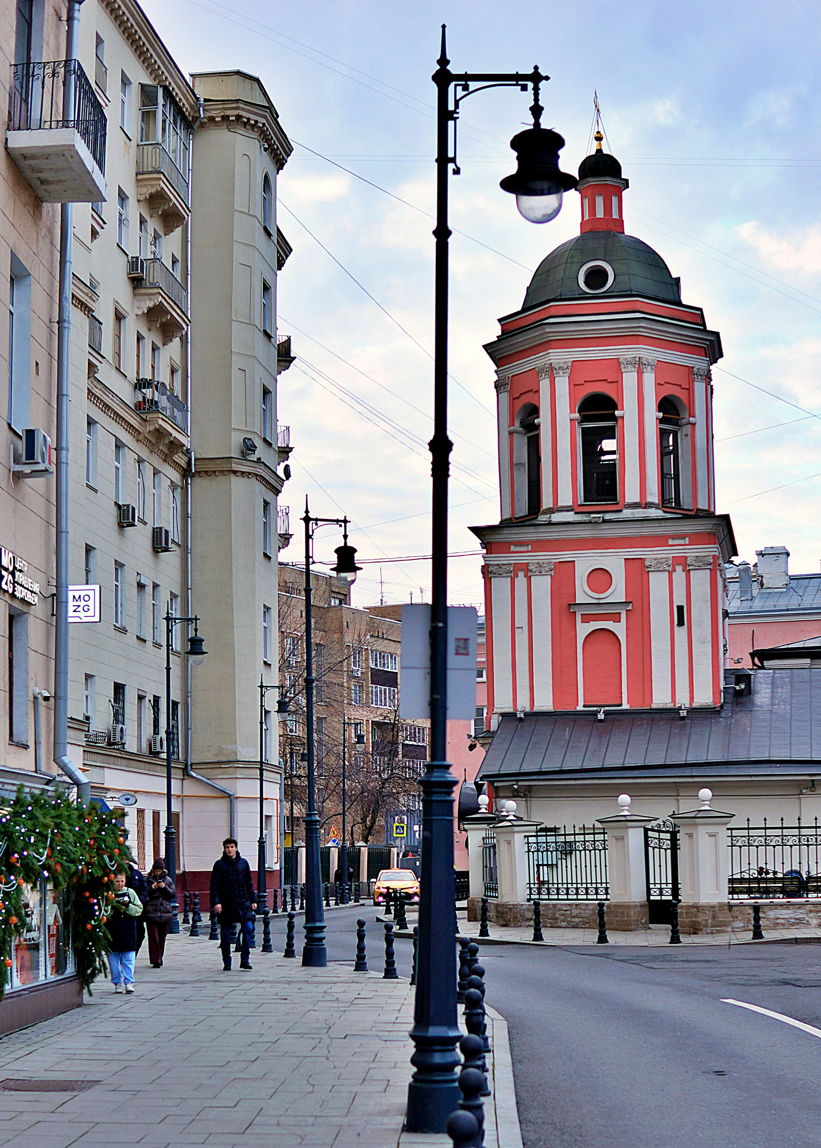 Pastel church tower amid a city street
