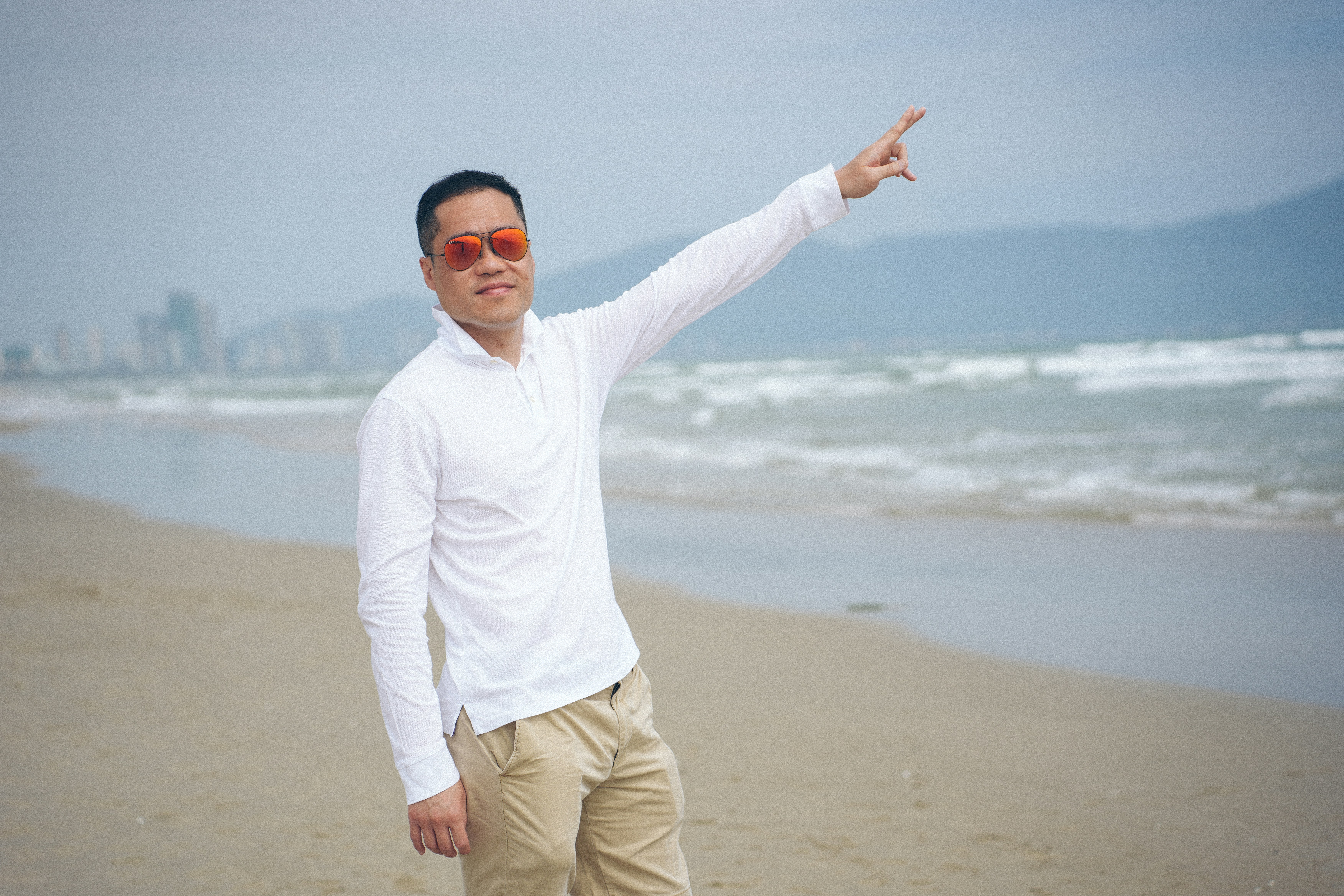 Beachside flare: a confident gesture against a panoramic coastline