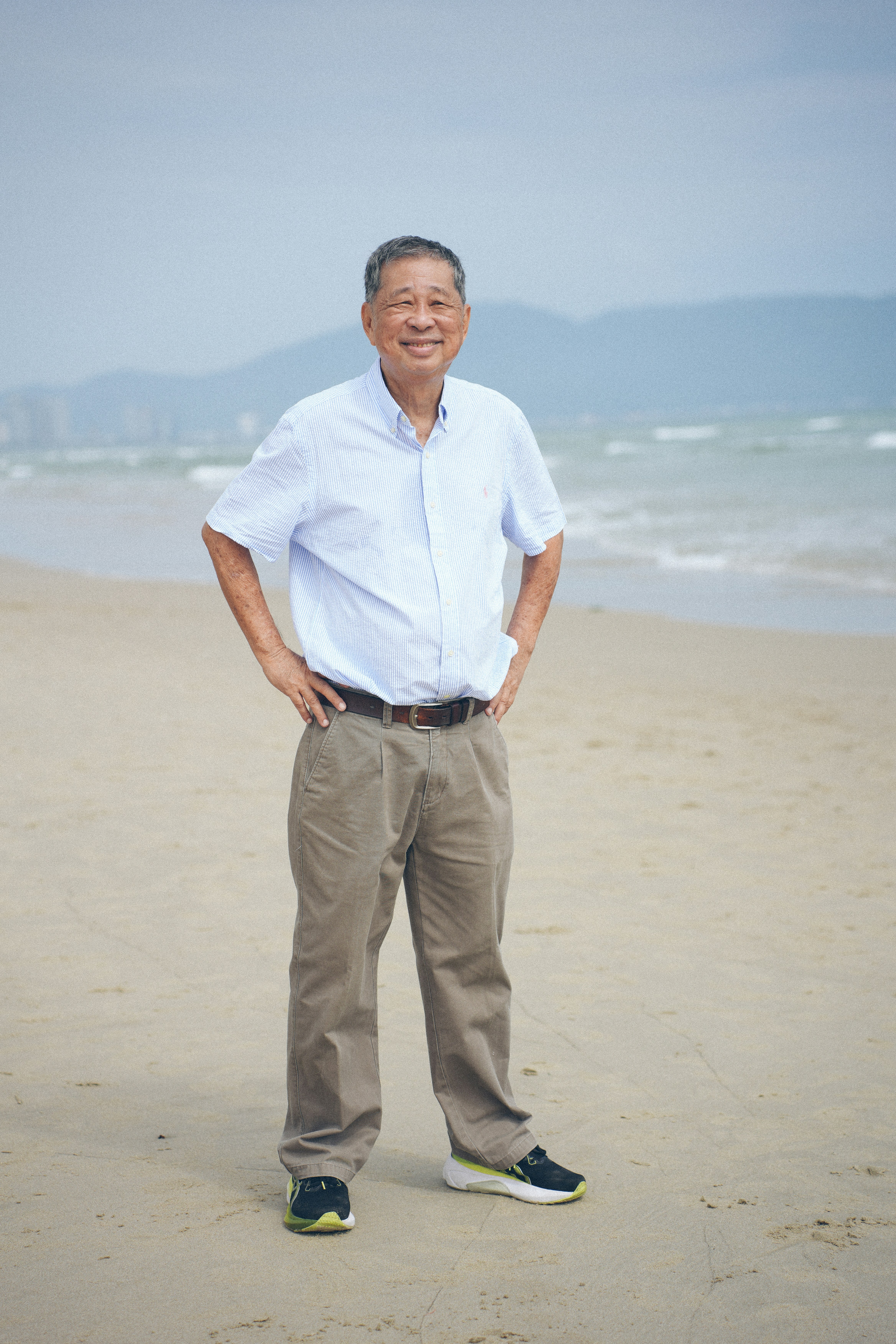 Smiling on the Shore: A Confident Elder on a Quiet Beach