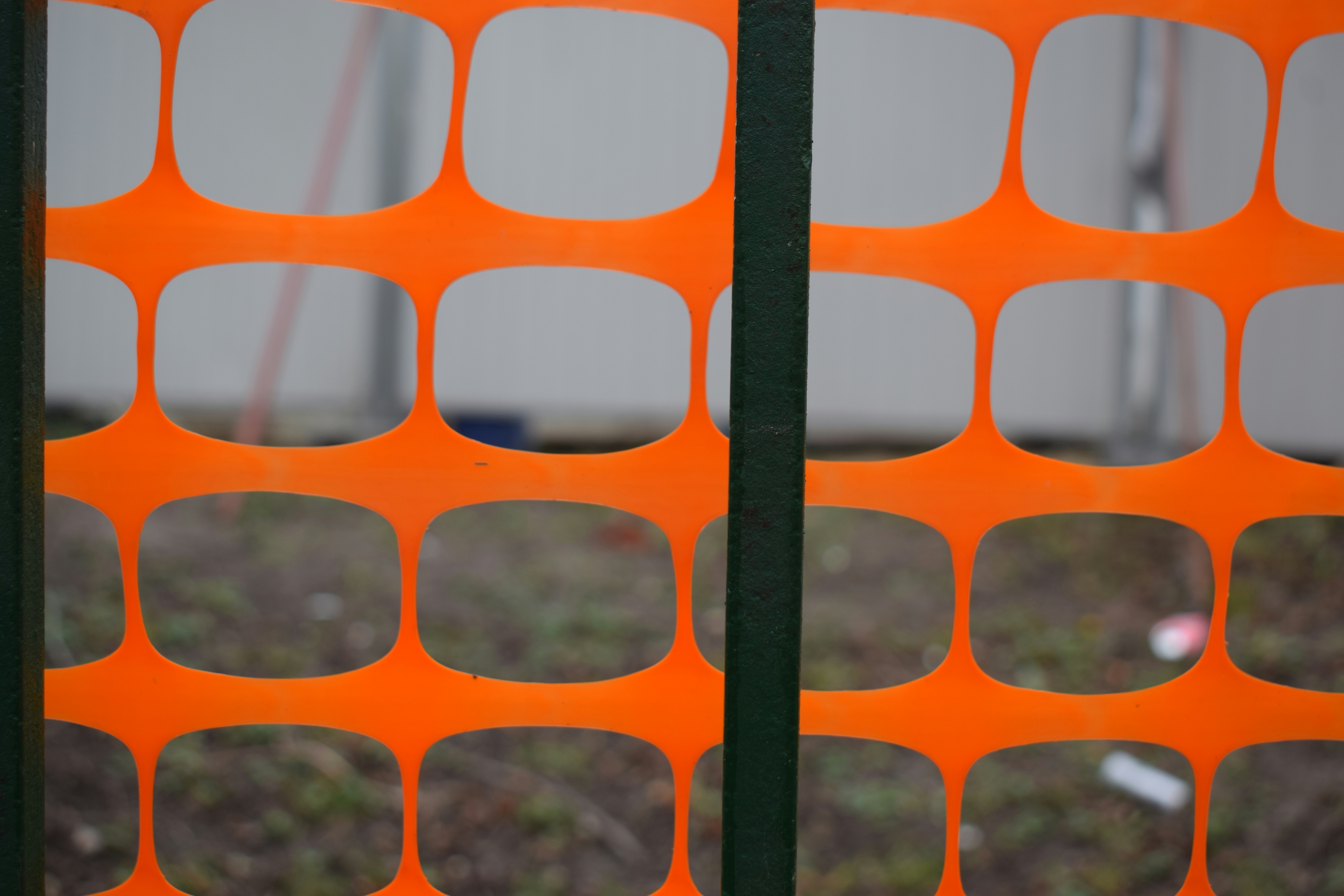 Center Gap: Orange Barrier Framing a Bare Ground Scene