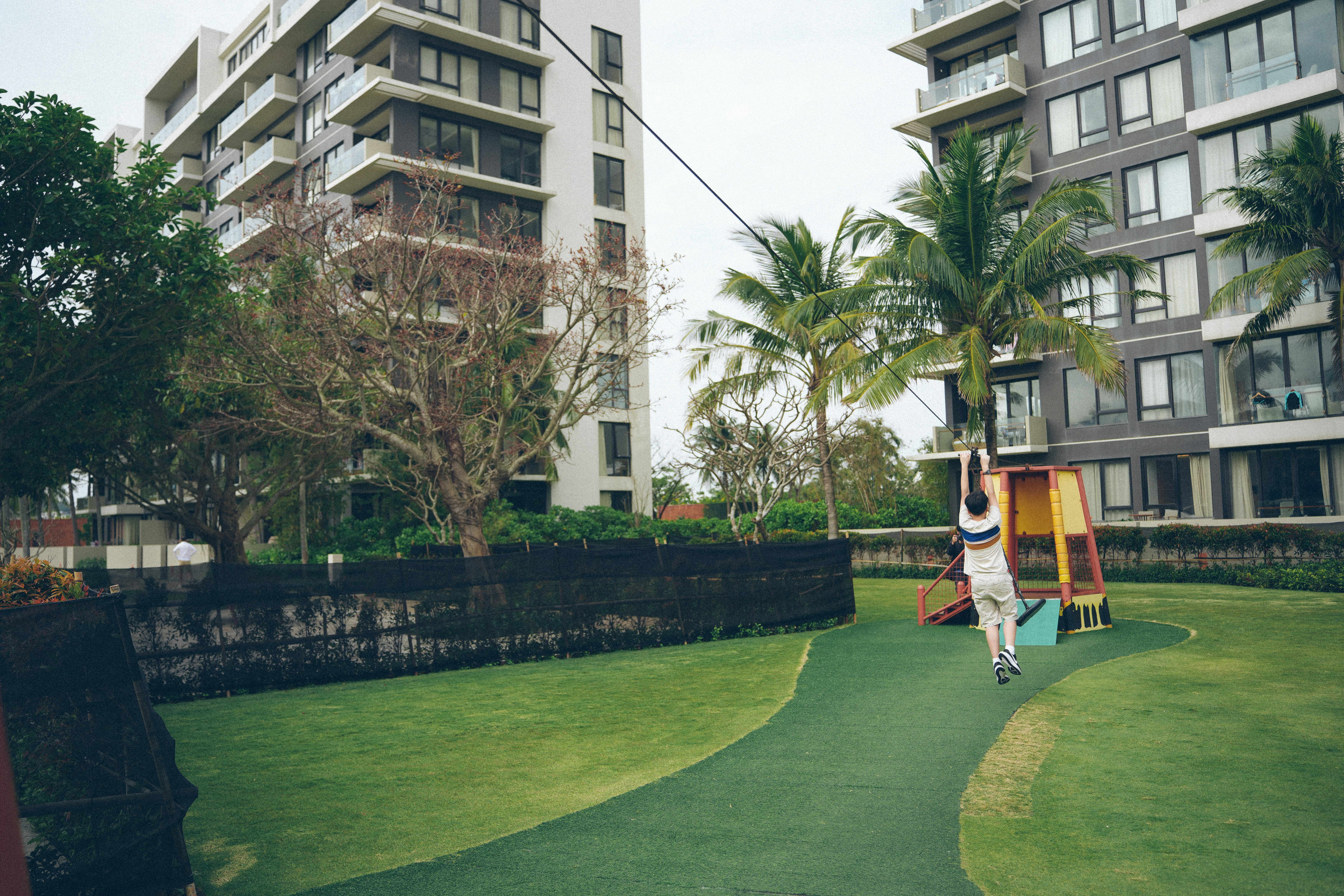 Swinging Toward the Sky: A Moment on the Green Courtyard
