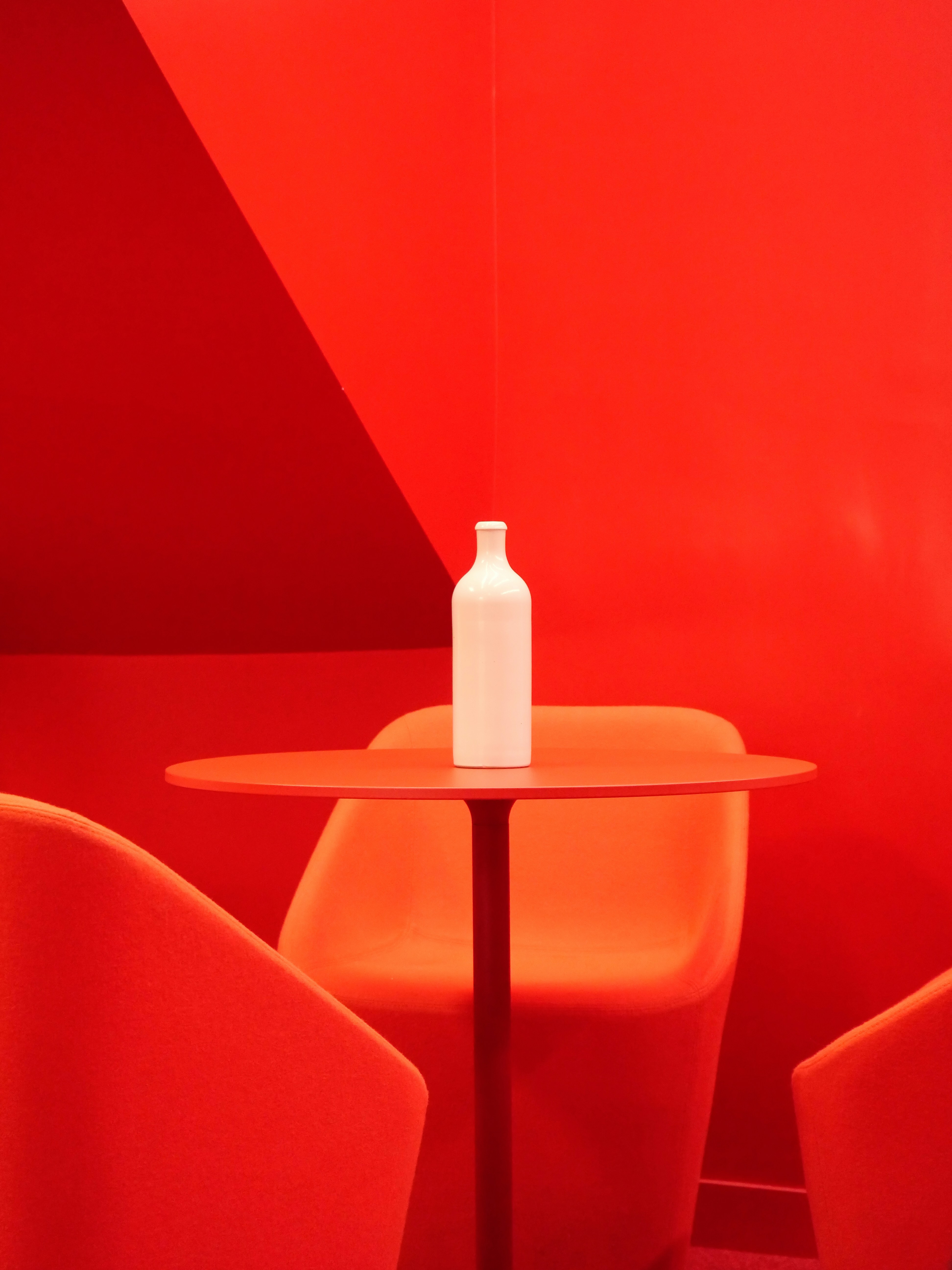 Minimal Red Café: A Single Bottle Centered on a Round Table