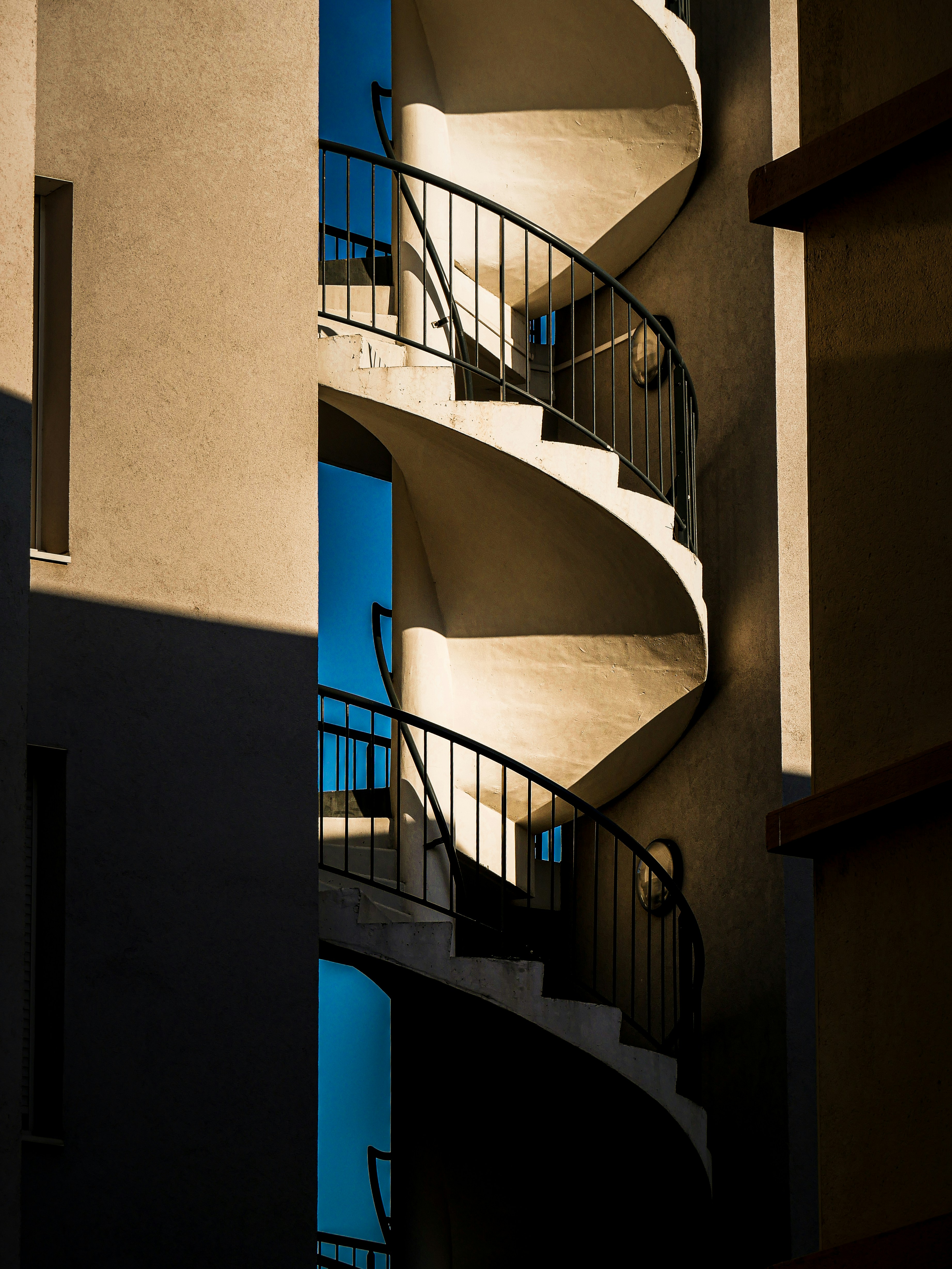 Spiral Staircase in a Sunlit Courtyard