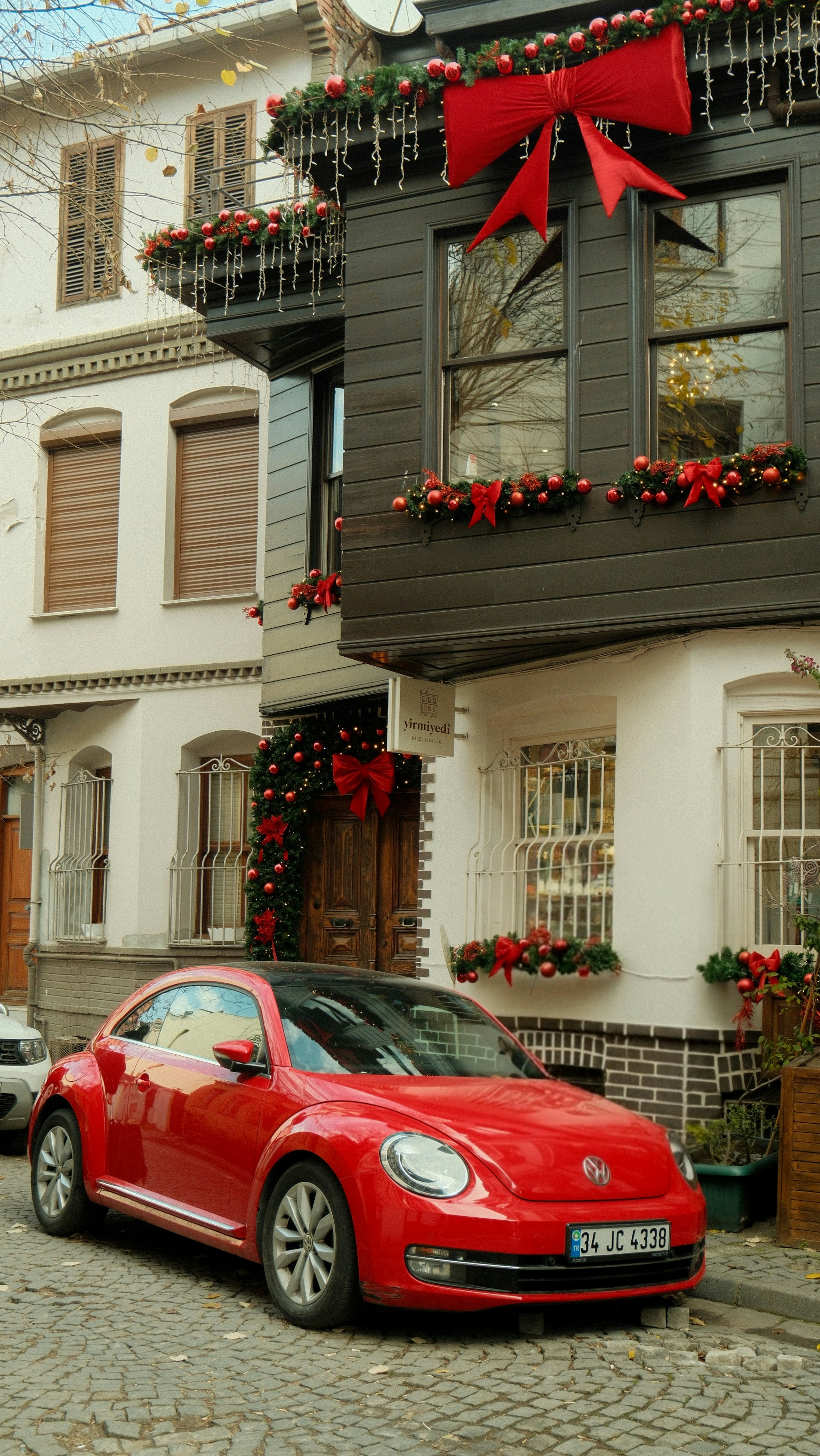 Red Volkswagen in festive street embrace of holiday decor