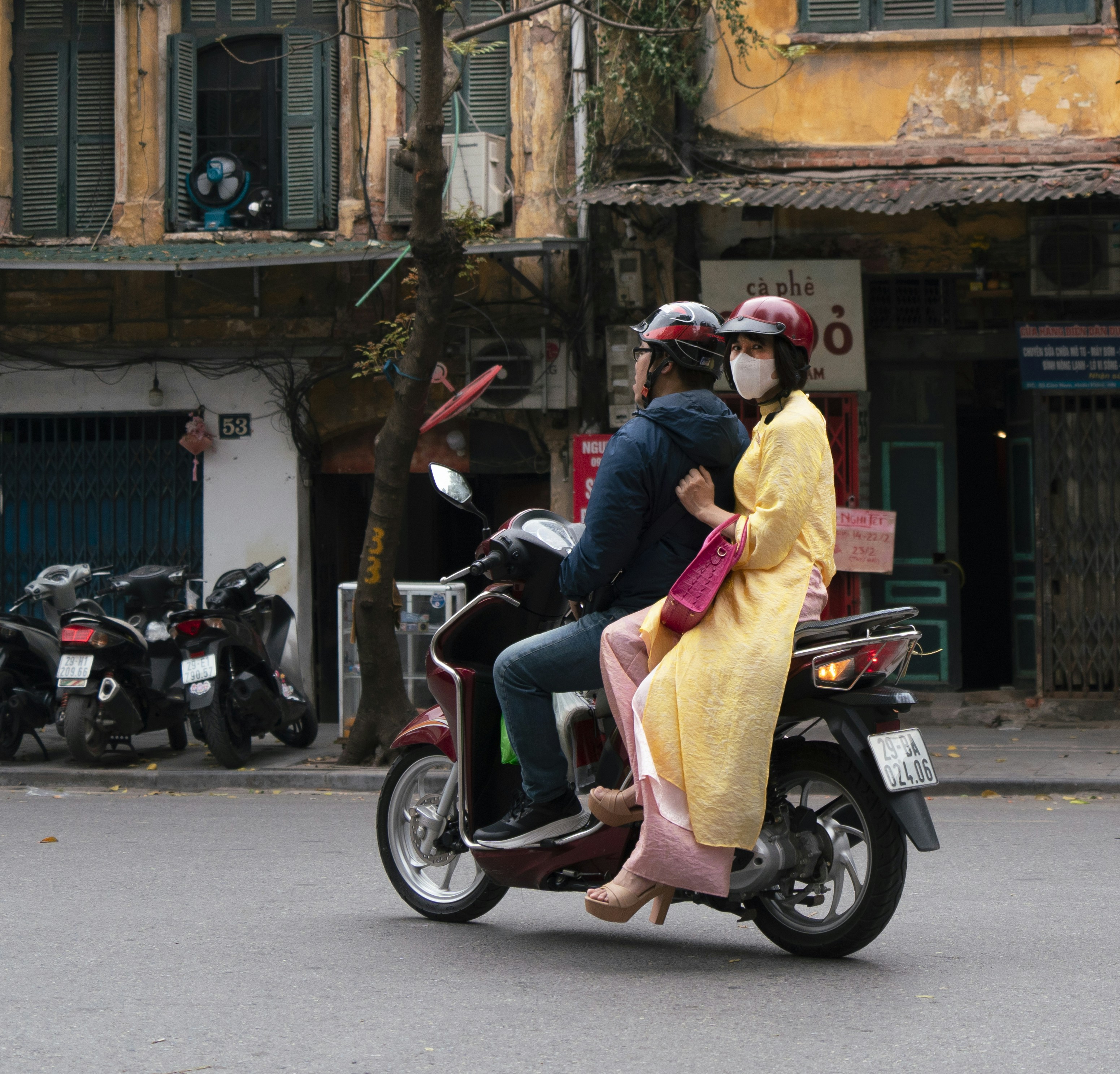 Yellow Coat on the Move: A Duo on a City Scooter