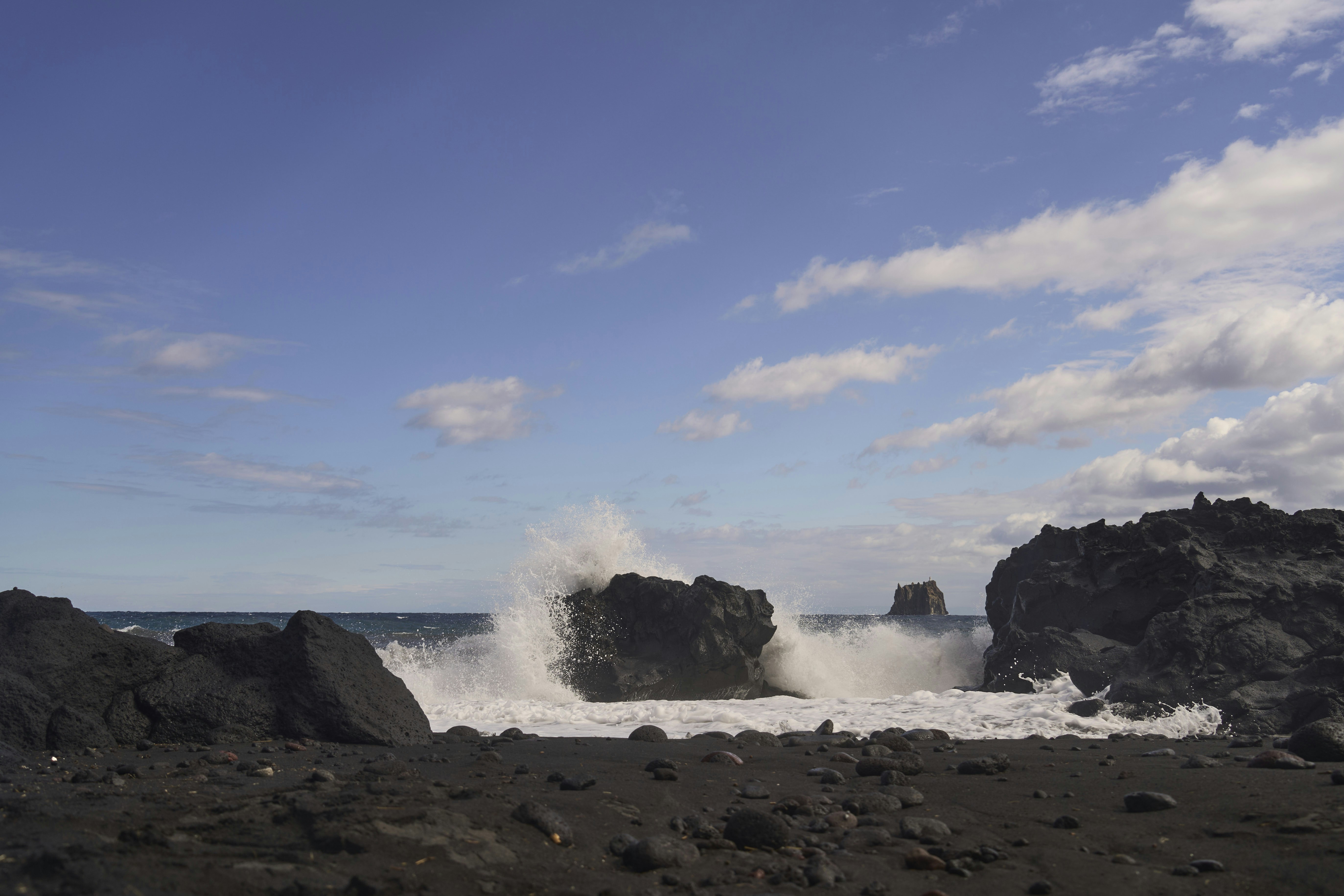 Foam Crown on Black Sand: A Wave-Worn Shoreline