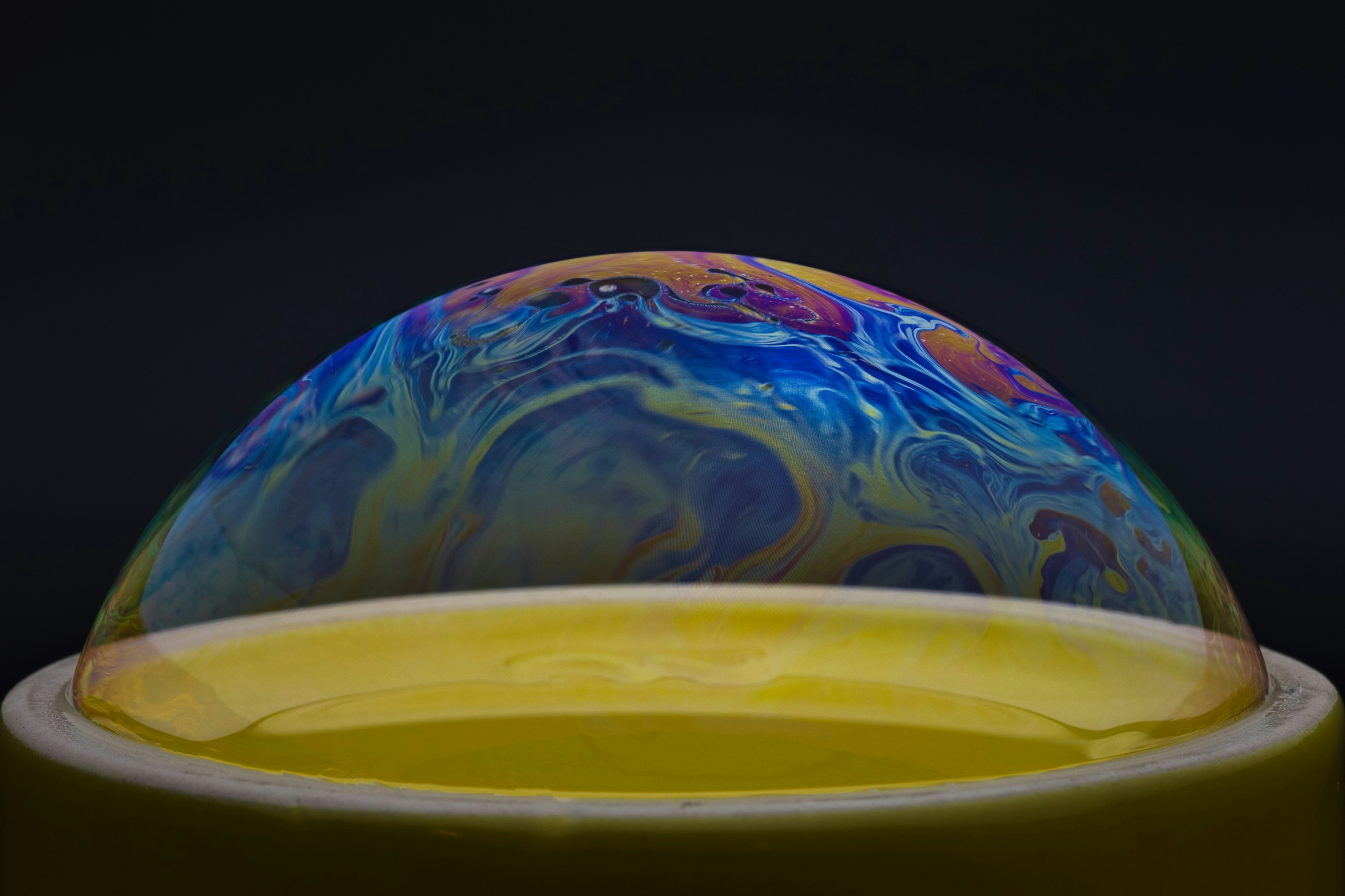 Floating Kaleidoscope: A Soap Bubble Halved by a Yellow Rim