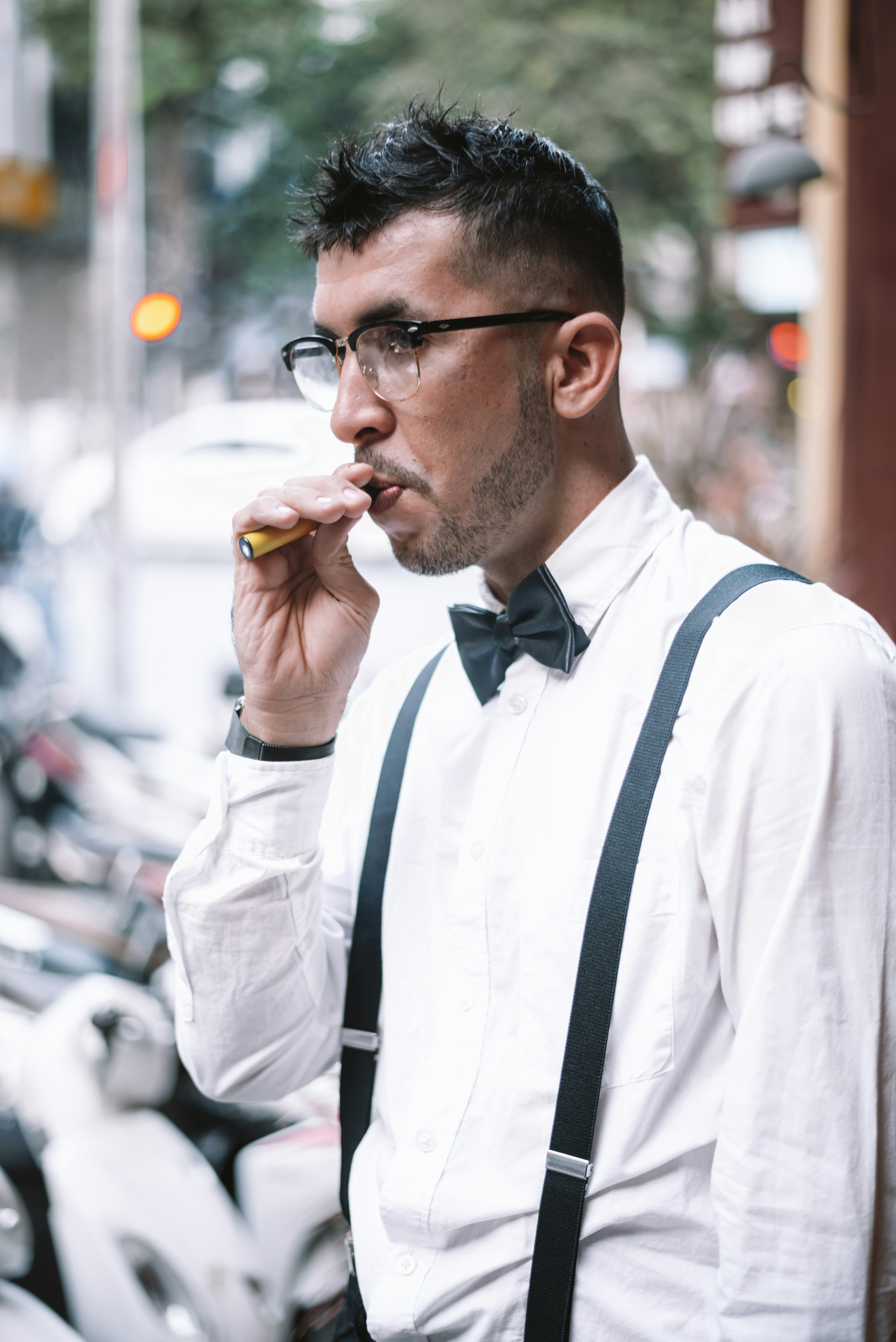 Cigarette-like gesture and bow tie: urban portrait in motion