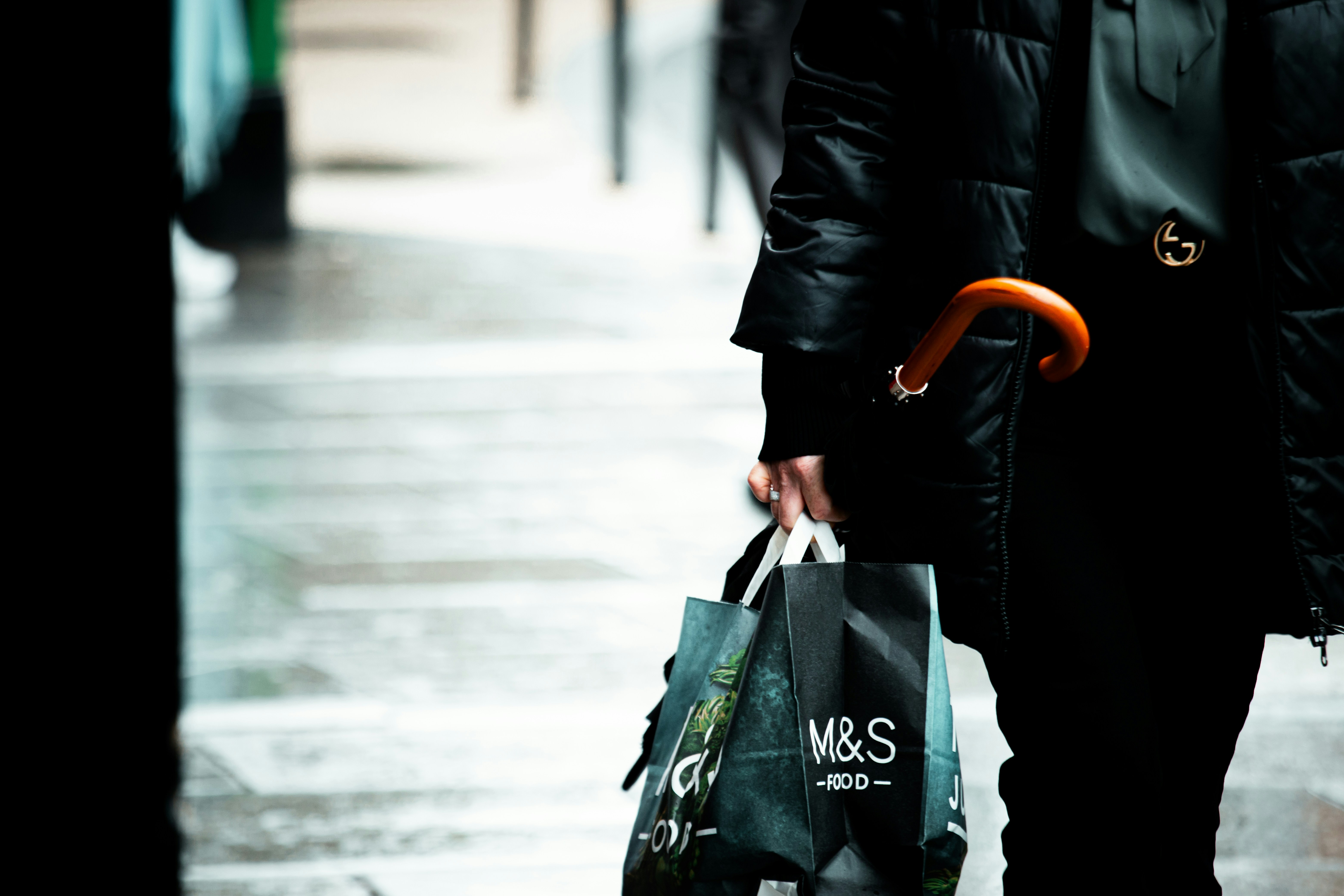 Under the Edge of a Walk: Shopping Bags and a Bright Orange Handle