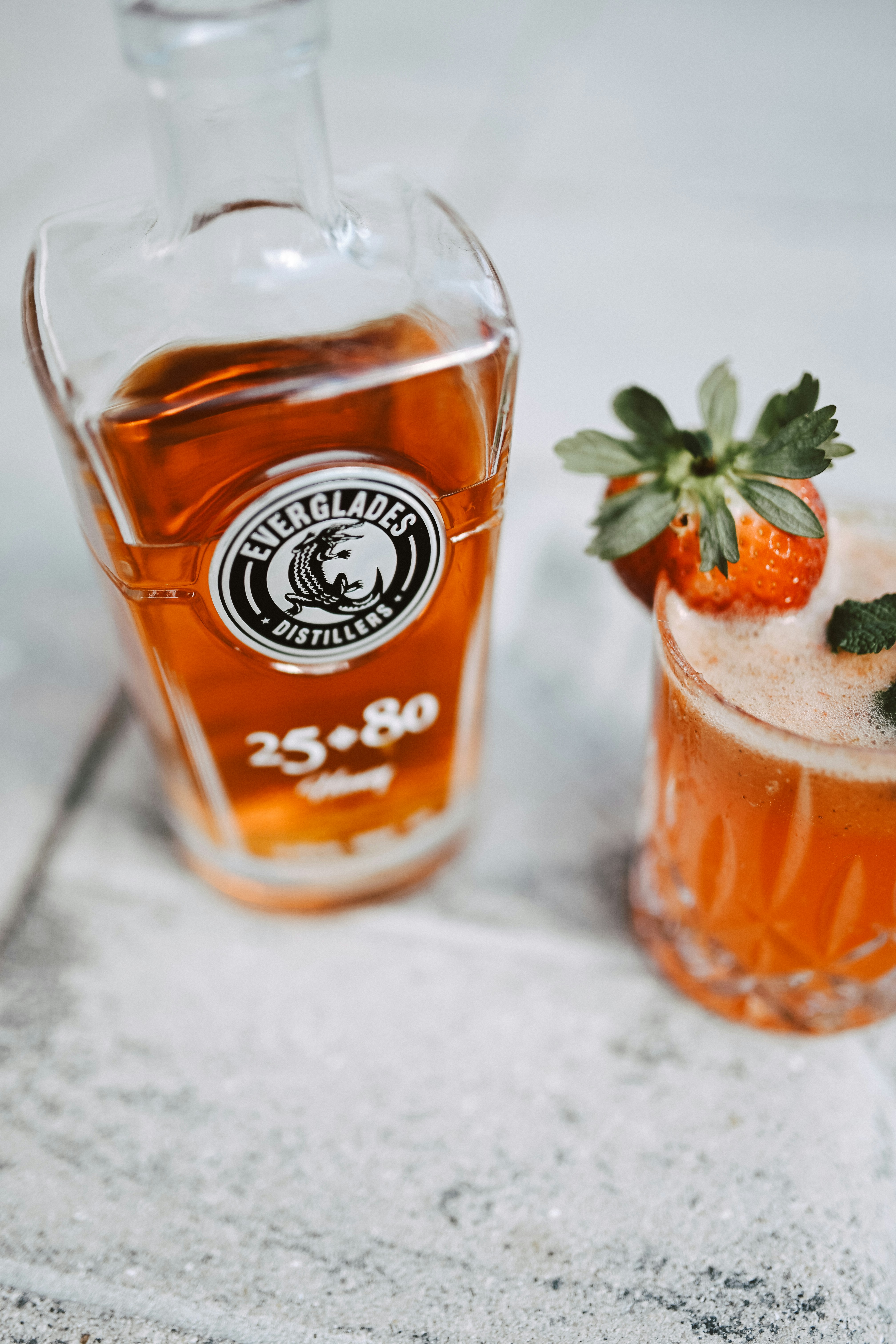 A bottle of rum with a strawberry cocktail