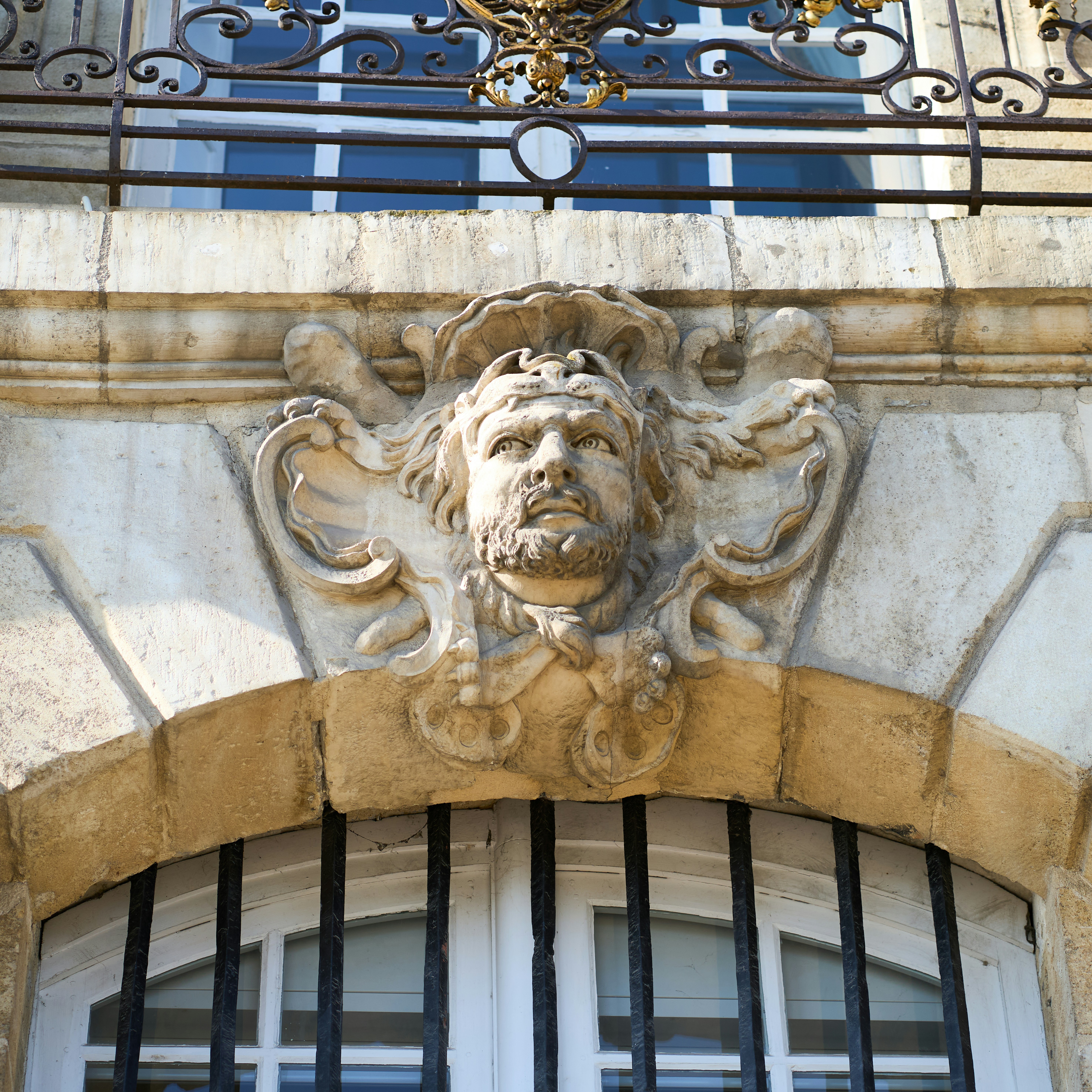 Stone Lyre: A Carved Face Above the Archway