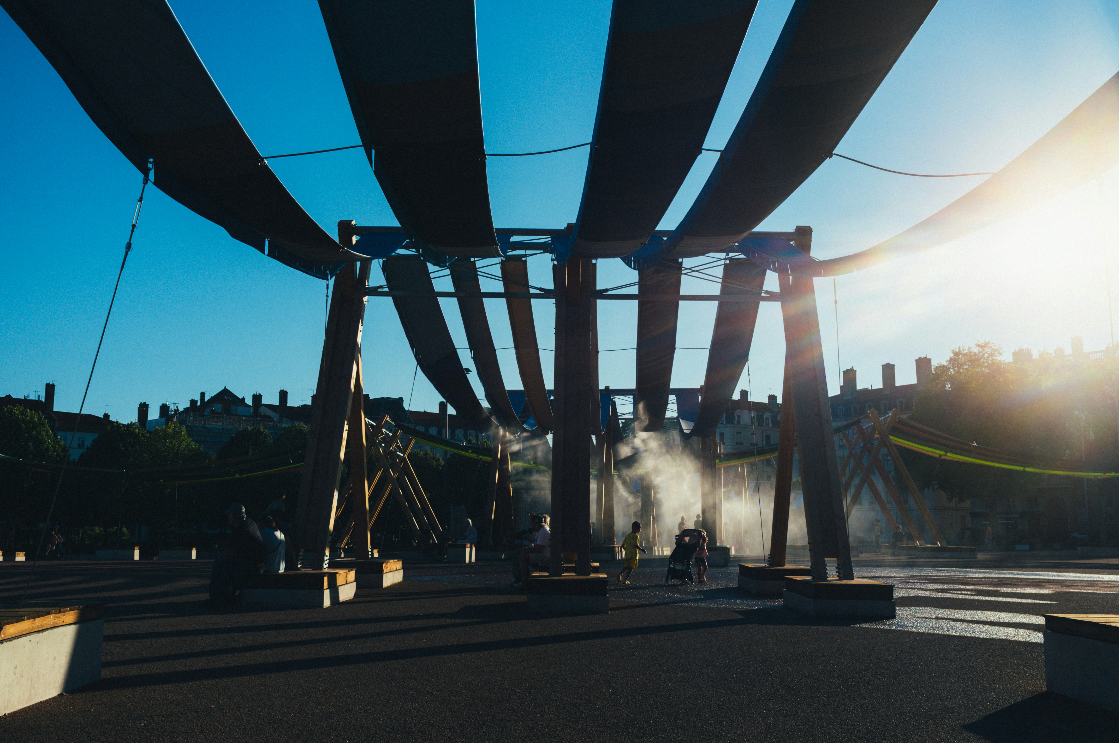 Suspended Canopy Over the Playground: Sunlight Framing a Steam Mist Scene
