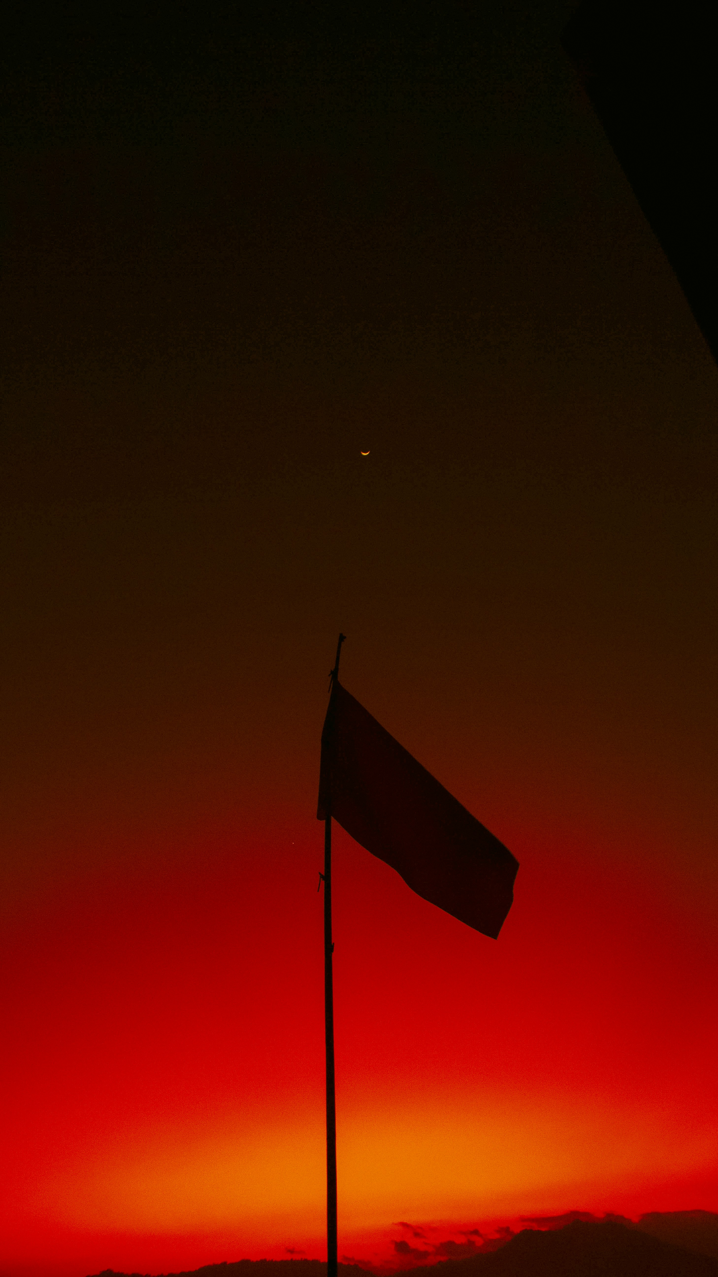 Silhouette of a Flag against a fiery twilight