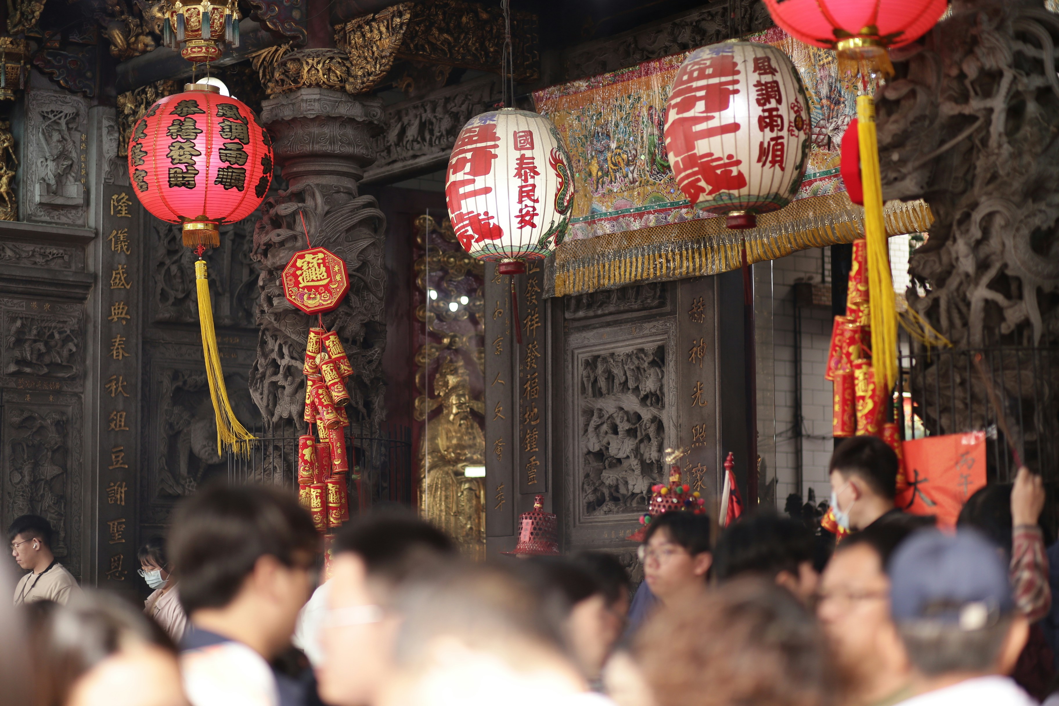  lantern-lit temple facade framed by a sea of visitors