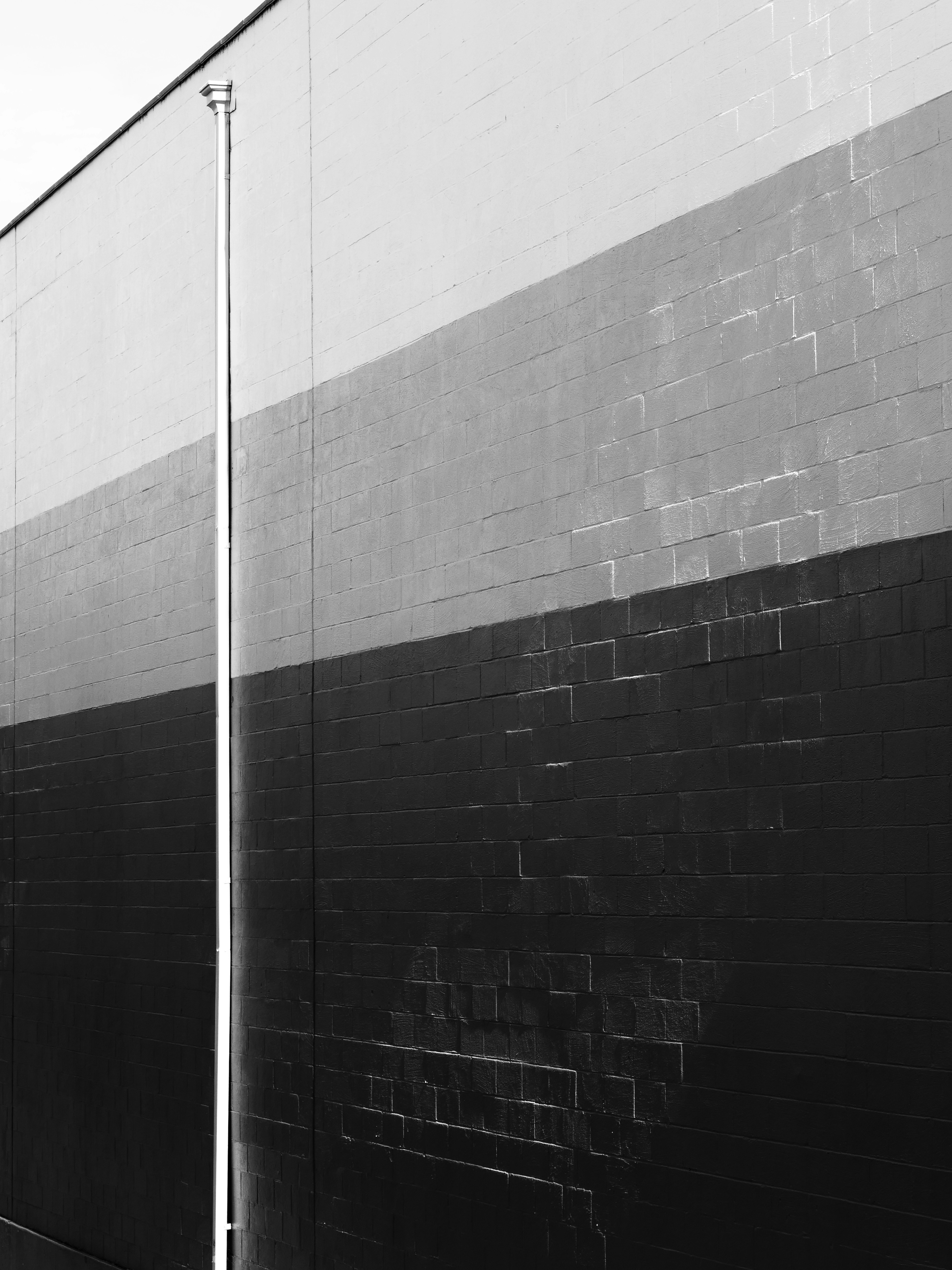 Vertical Pole Against a Striped Wall: Monochrome Geometry