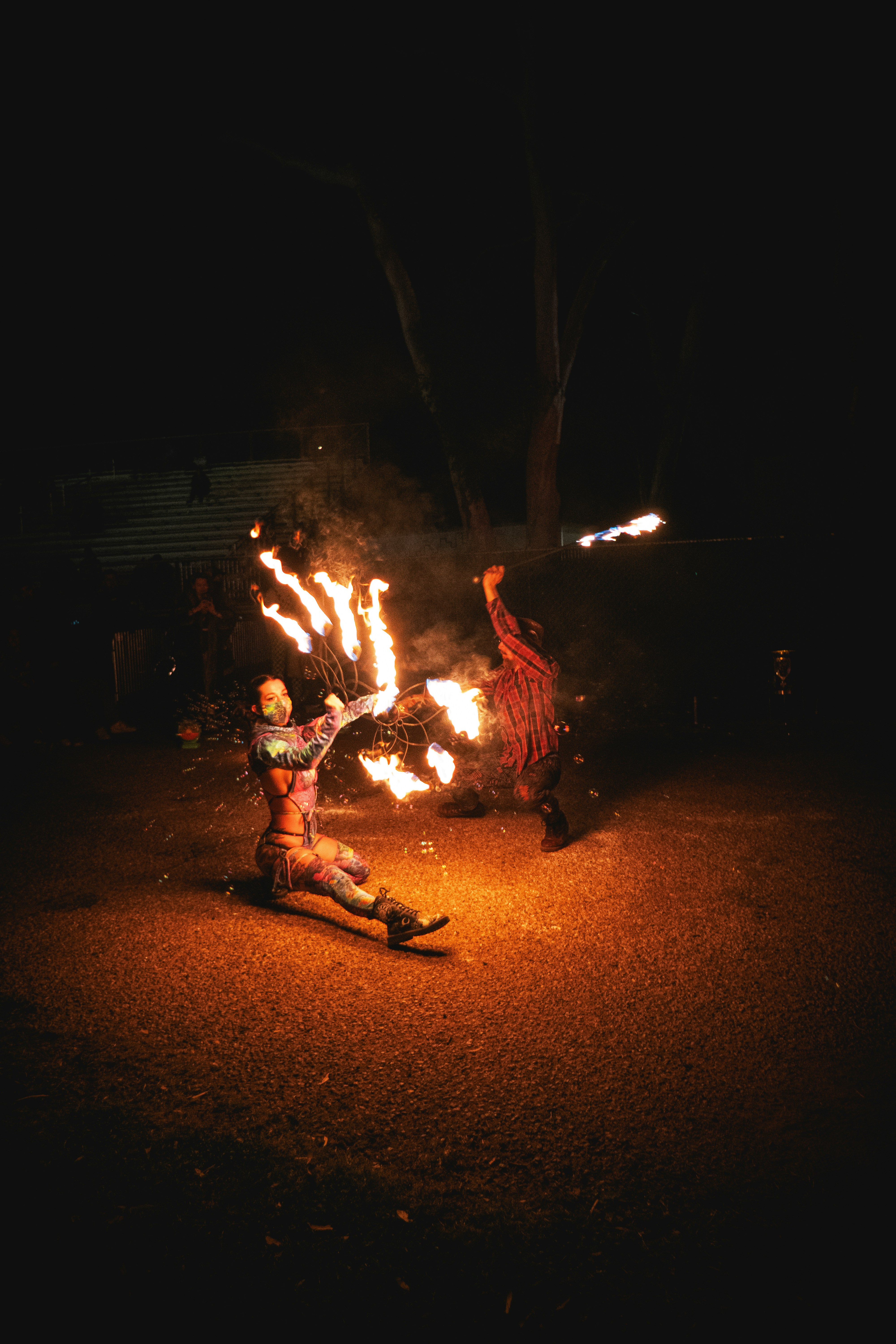 Fire Dance Under Night Skies: Two Performers Wielding Flames