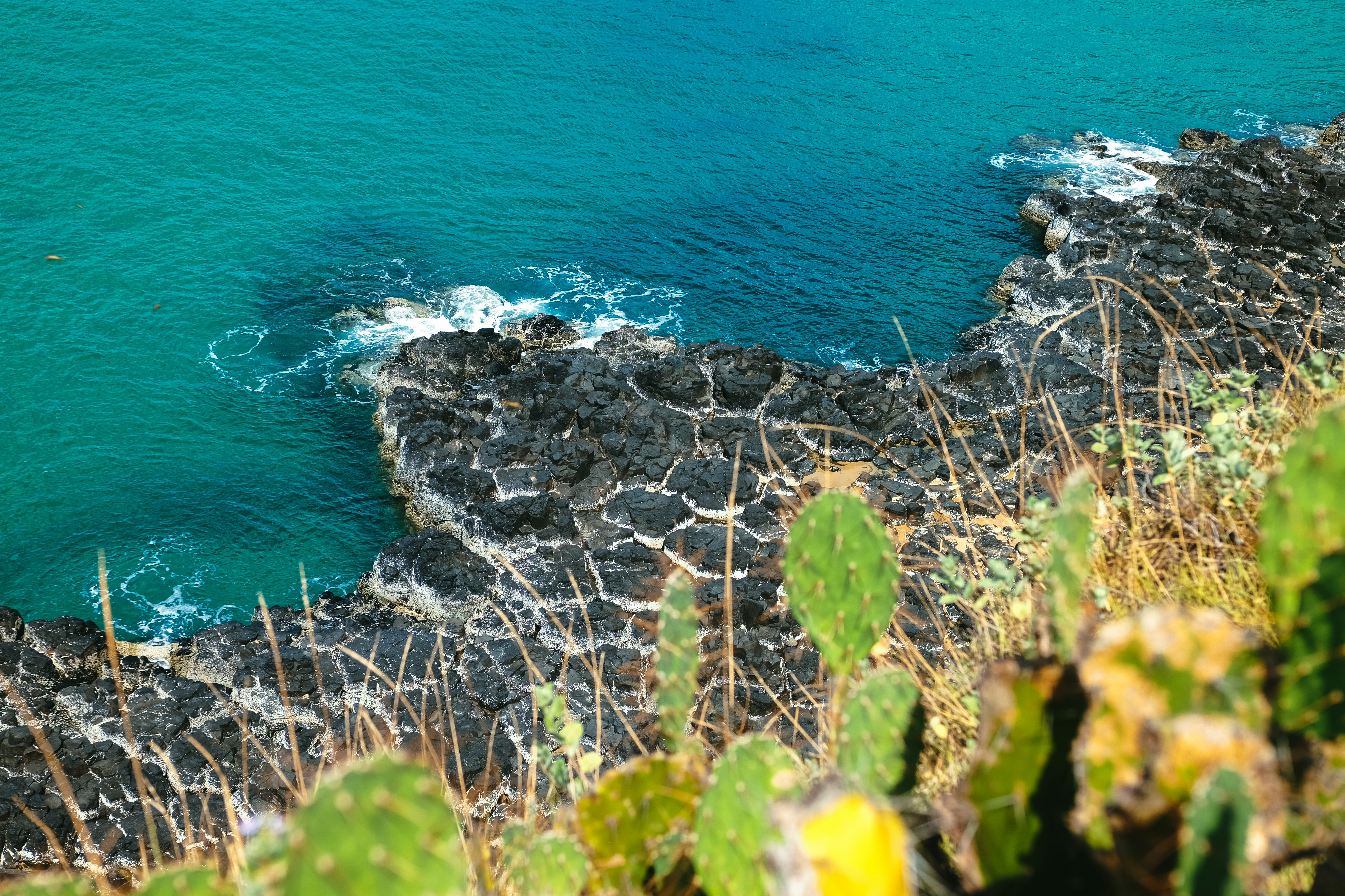 Azure Cliff Edge: Turquoise Waters Meet Weathered Rocks
