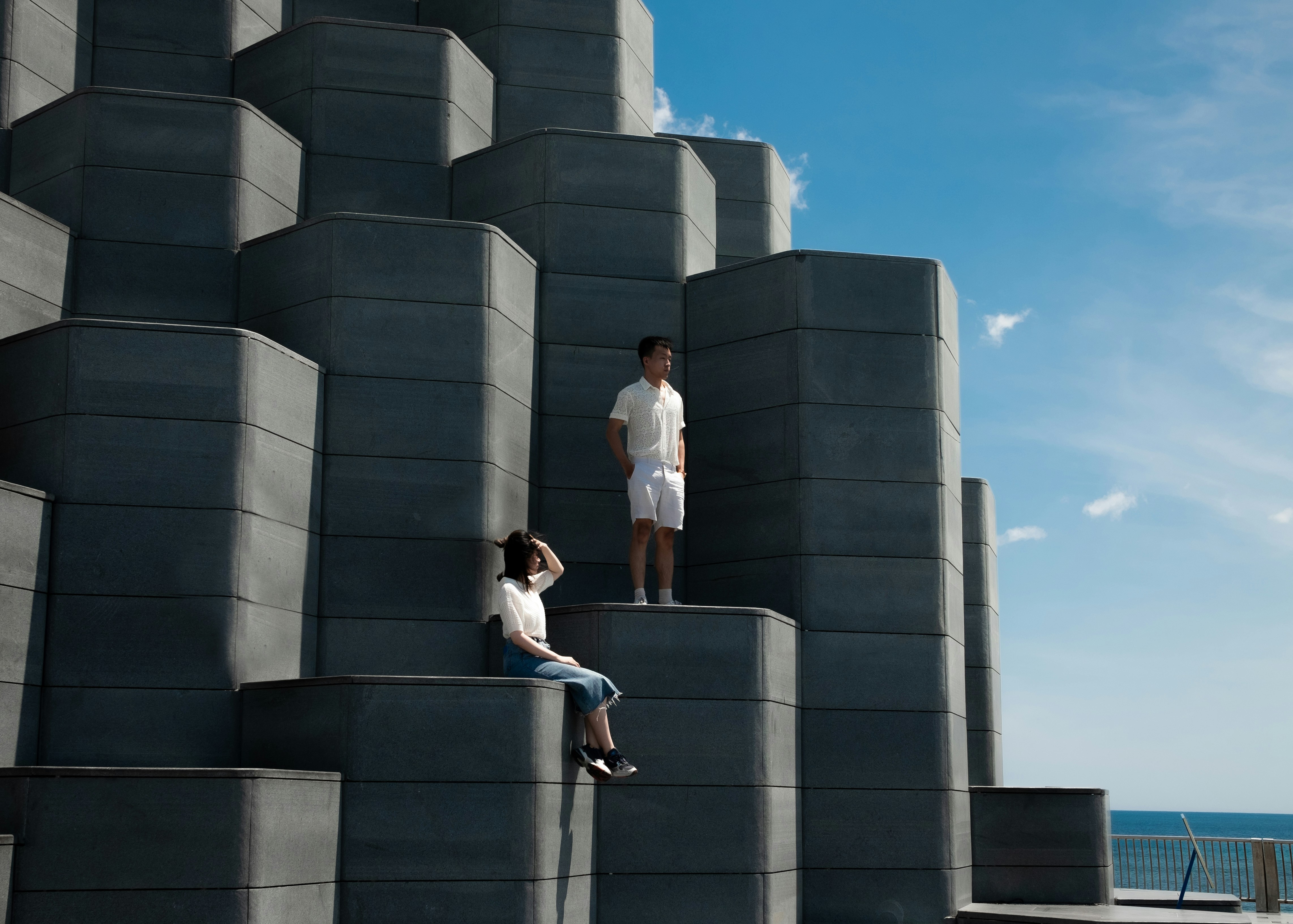 Sitting and Standing Against Giant Concrete Stacks by the Sea
