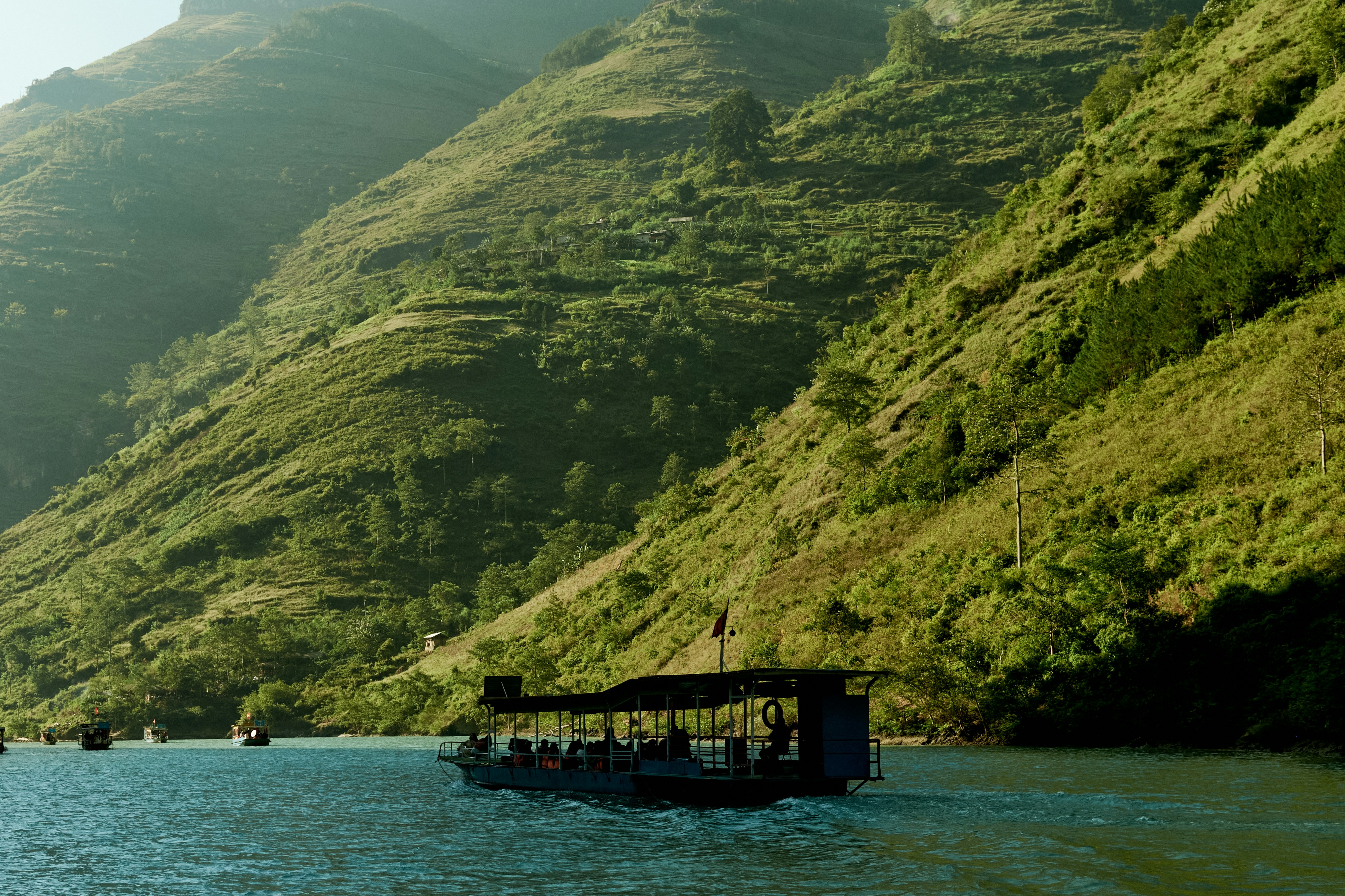 Moonlit River Run: A Boat Makes Its Way Through Emerald Slopes