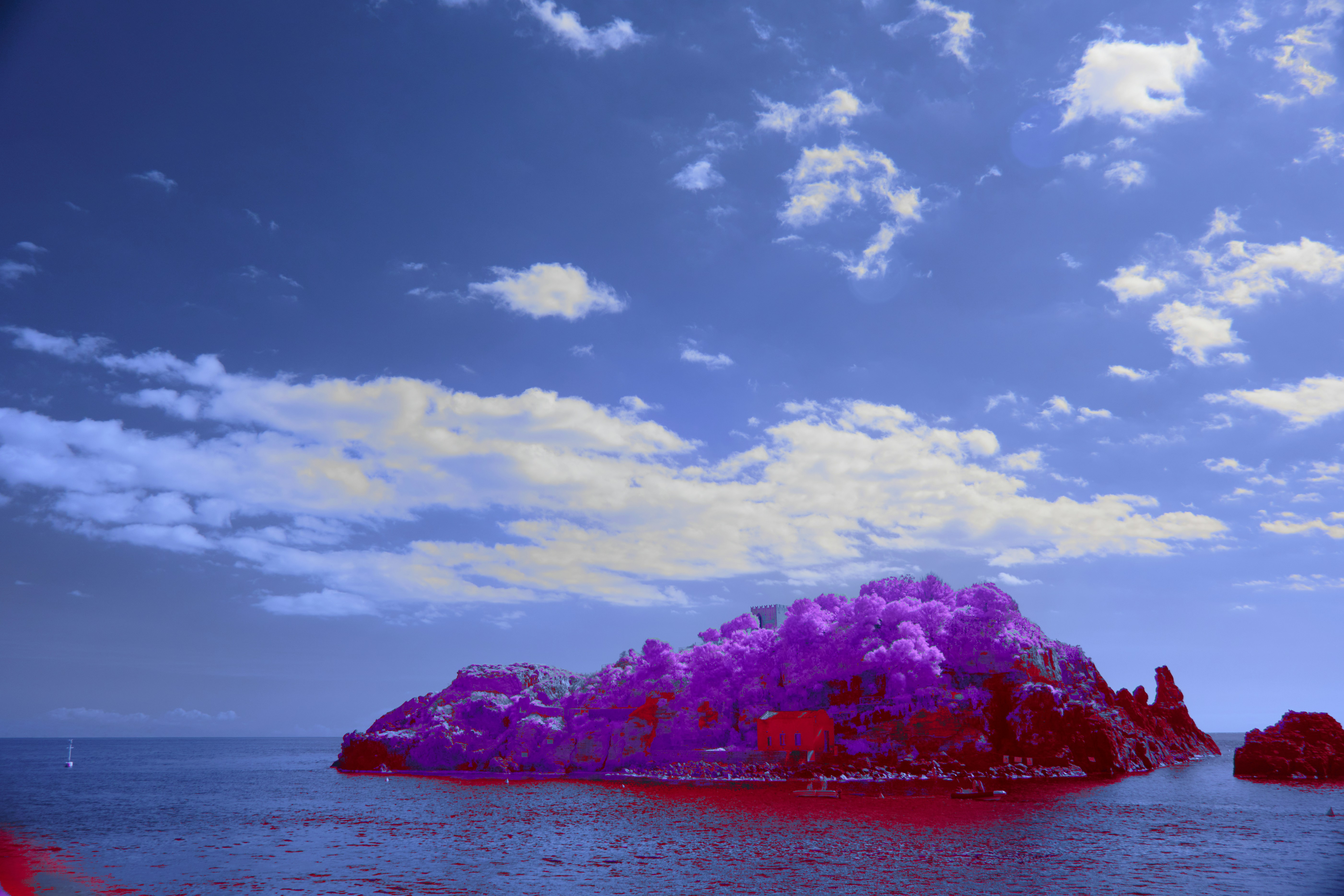 Crimson Coastlines: A Surreal Red-Hued Island under Clear Skies