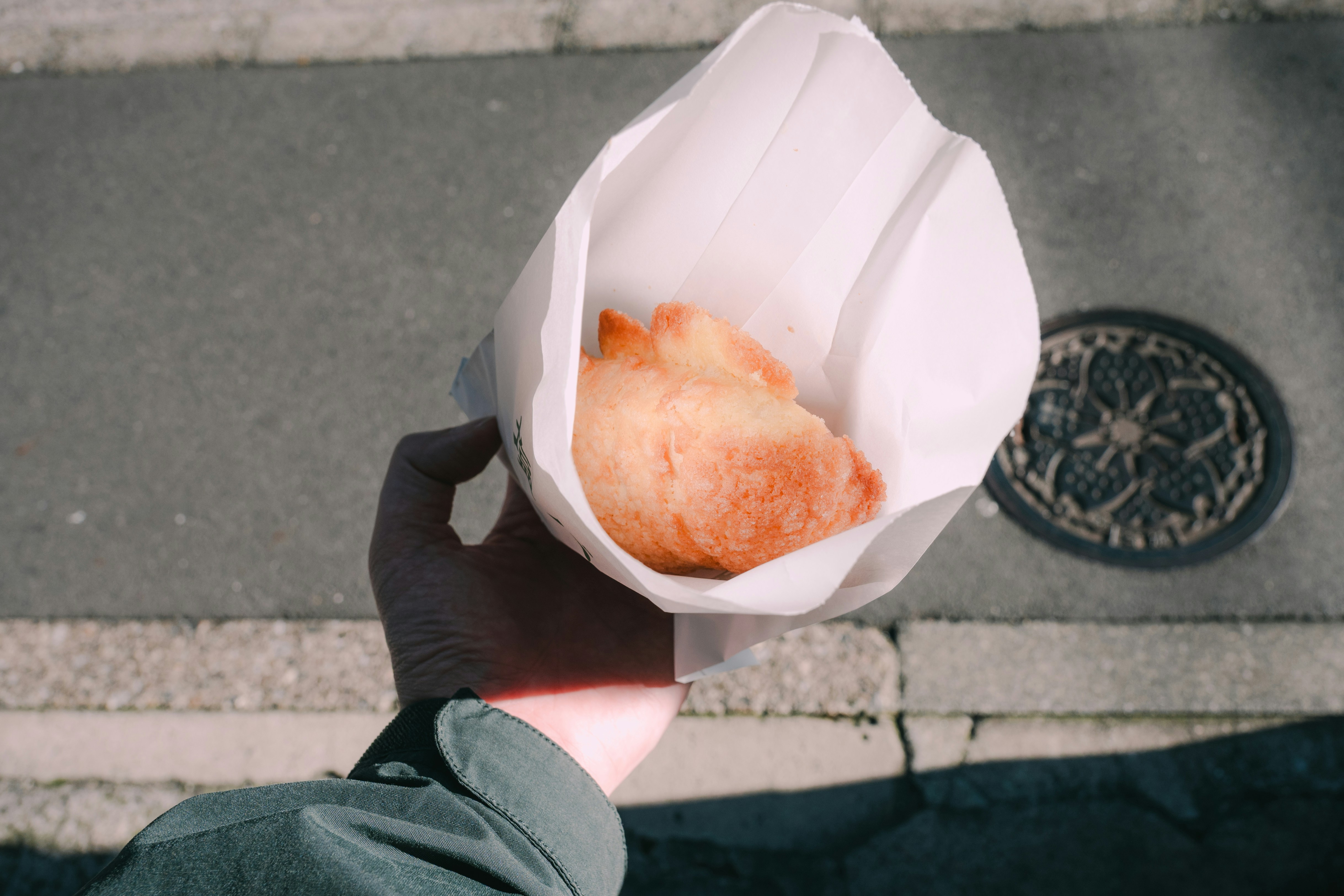 Handheld Snack in White Wrapping Against Urban Concrete