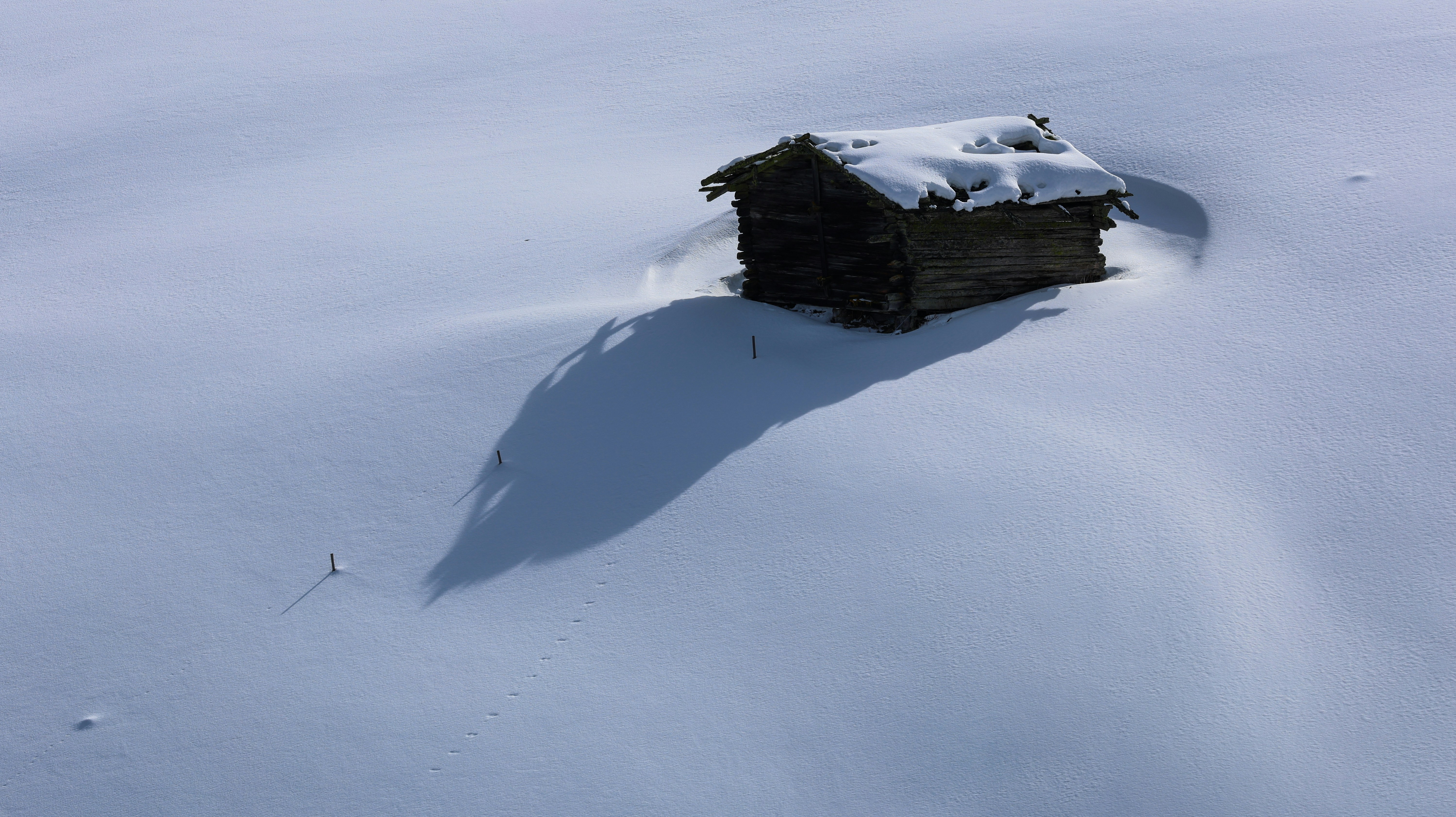 Snowbound Shelter: A Lone Slab of Wood Emerges from Quiet White Peaks