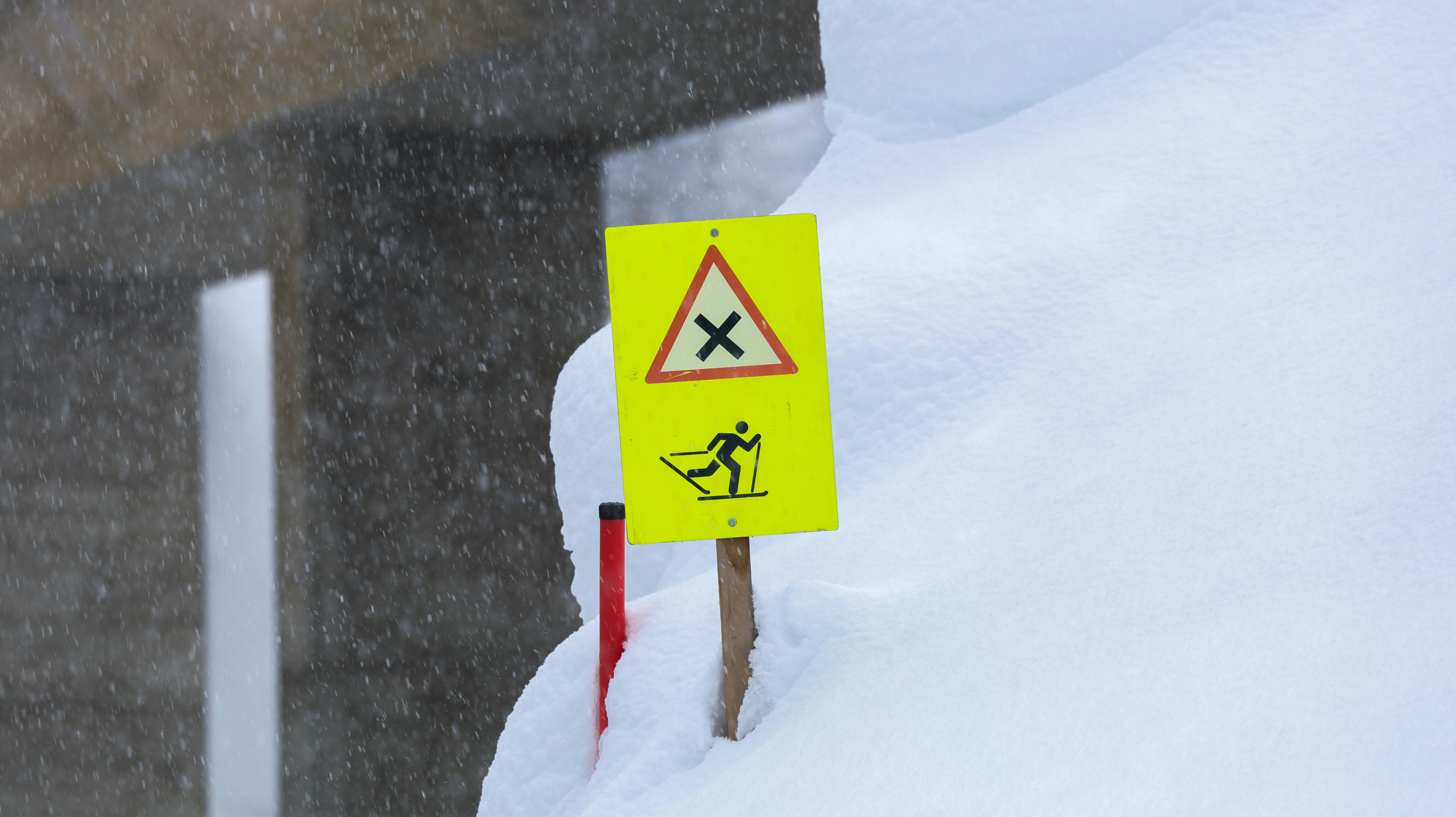 Bright Warning Sign Emerging from Snow Drift