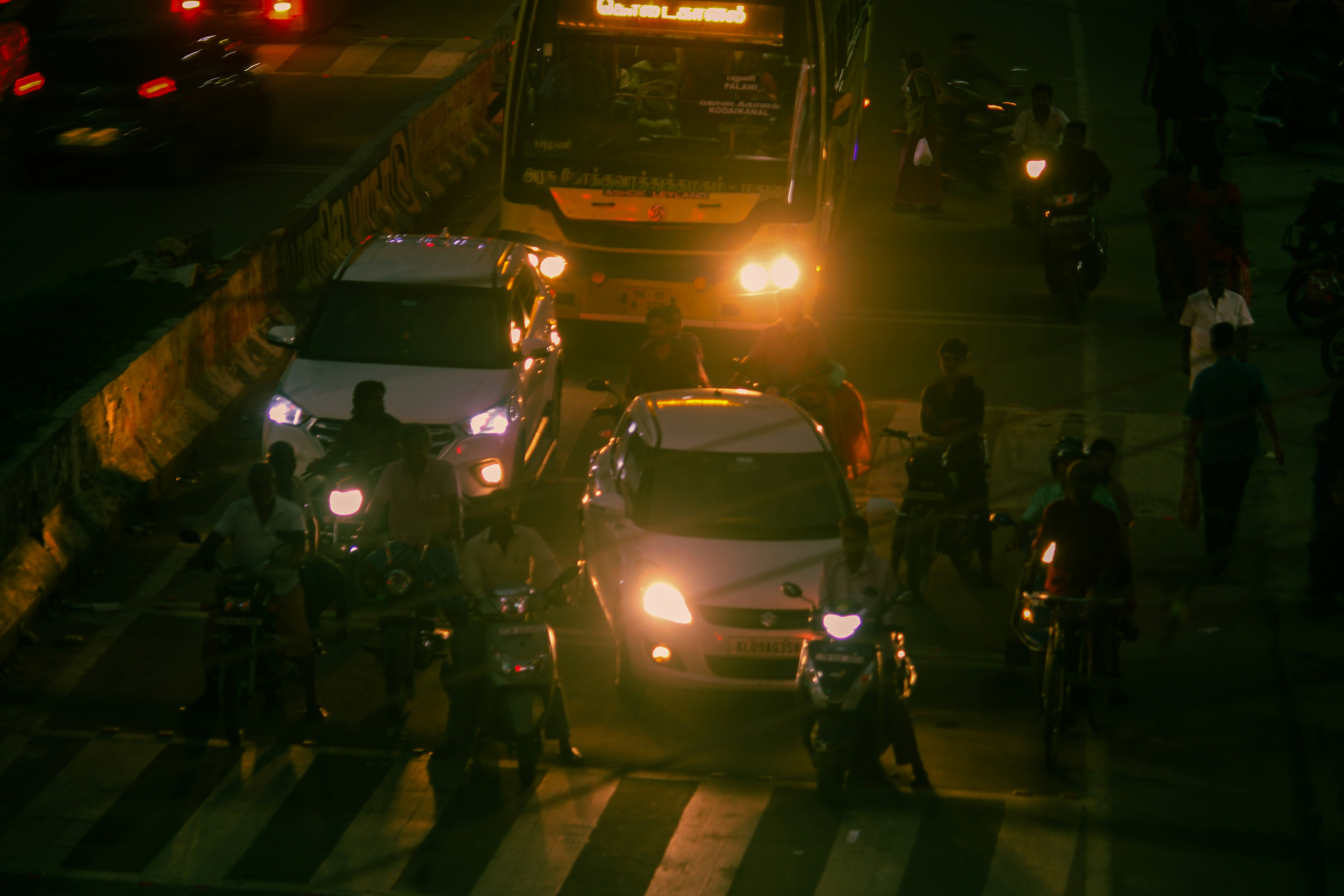 Night Street Jam: A Cluttered Crosswalk of Lights and Wheels