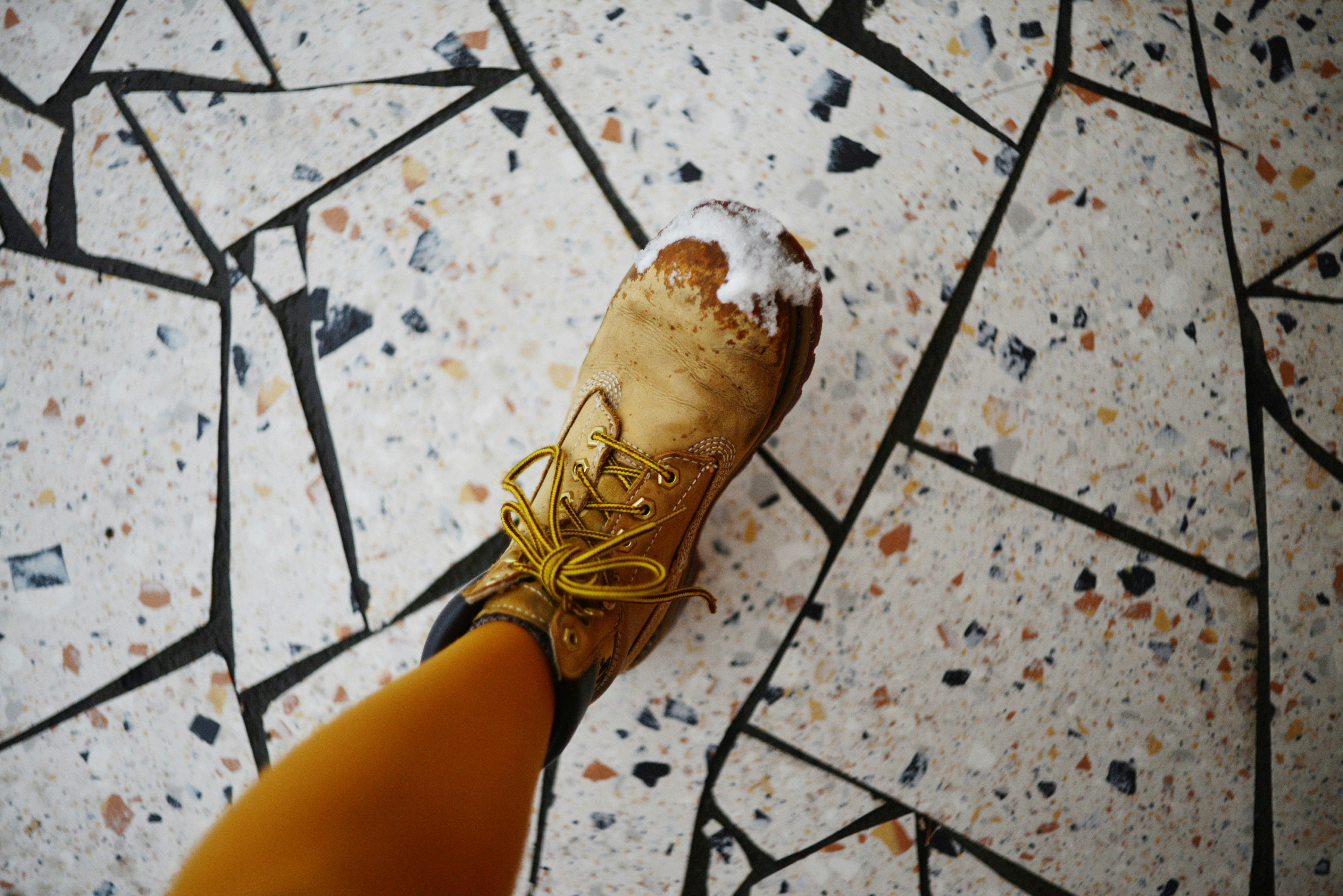 Boot Steps on Fragmented Floor: A Snowy Toe-Print Journey