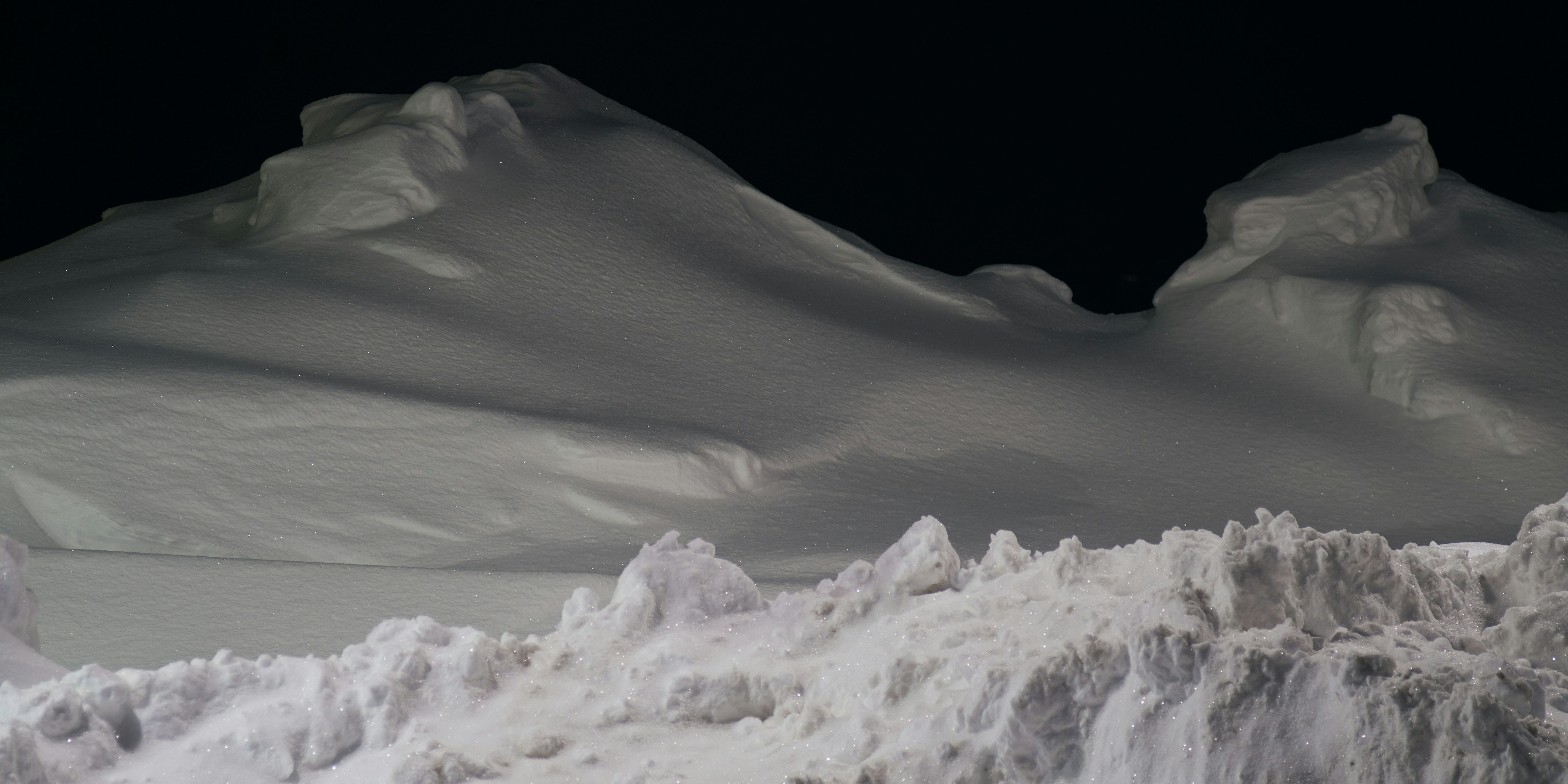 Moonlit Snow Peaks Behind a Slush of Snowdrifts