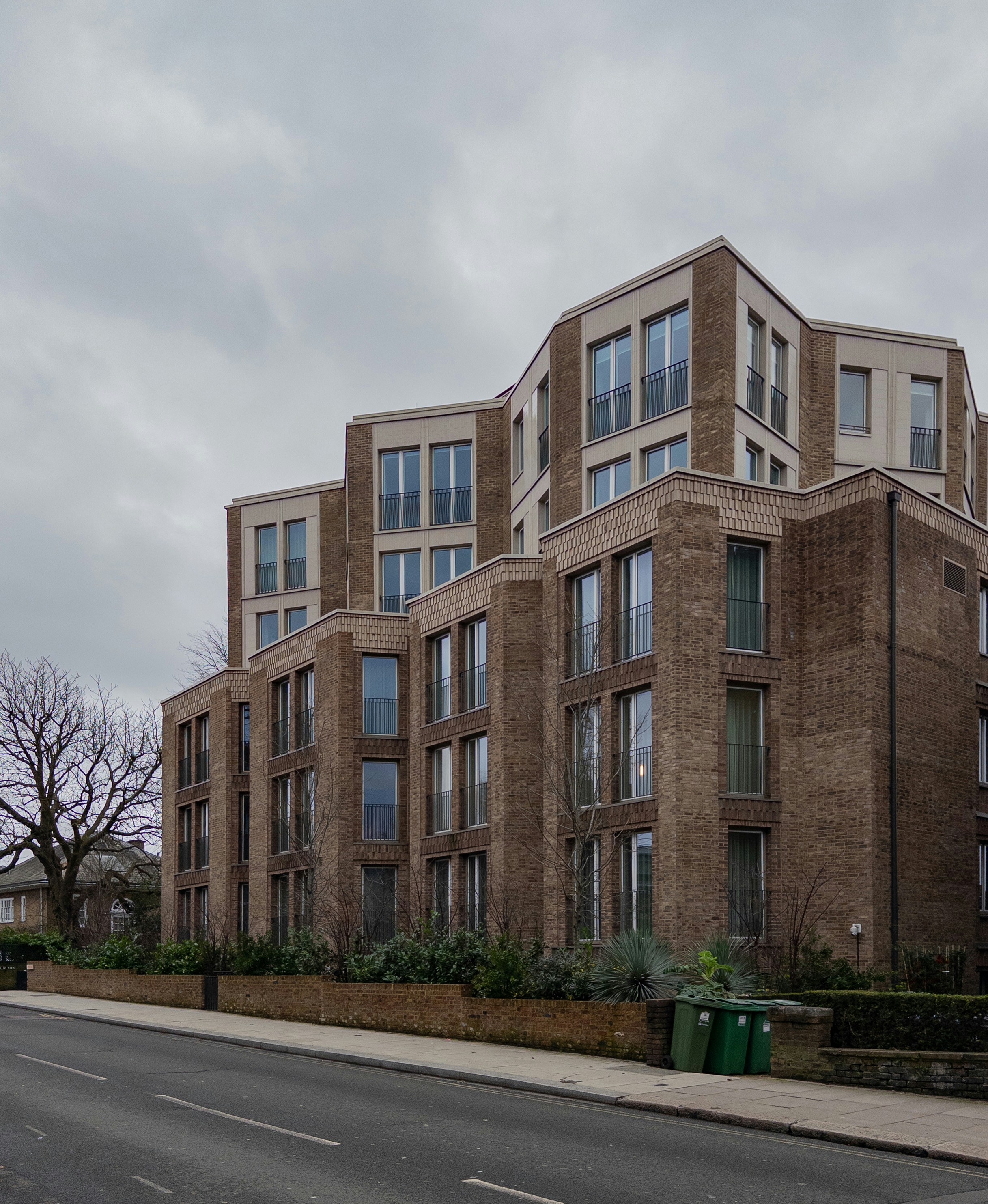 Brick Facade Rising: A Modern Apartment Block Against a Cloudy Sky