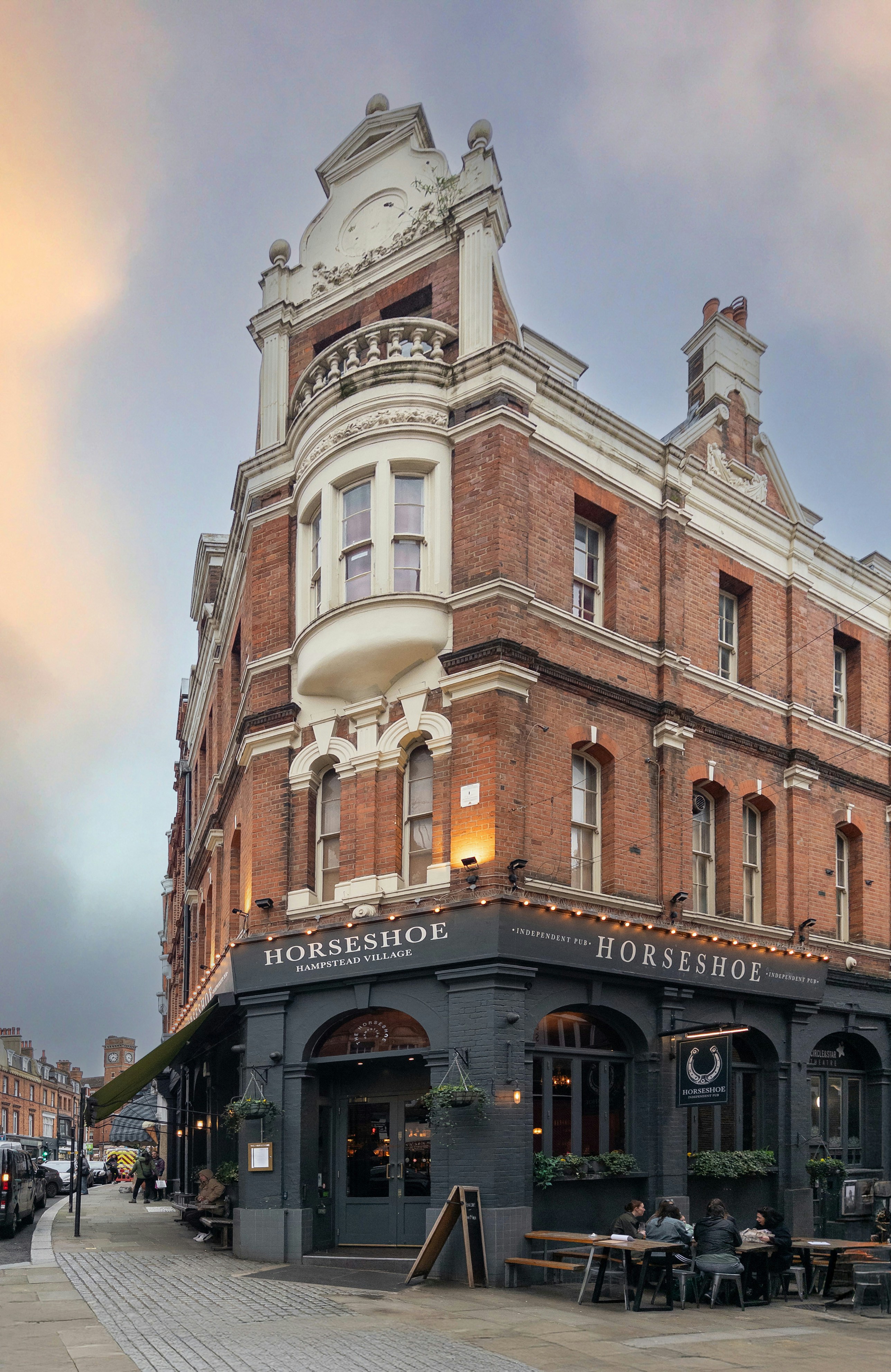 The Horseshoe Corner: Brick Facade and Lantern-lit First Floor