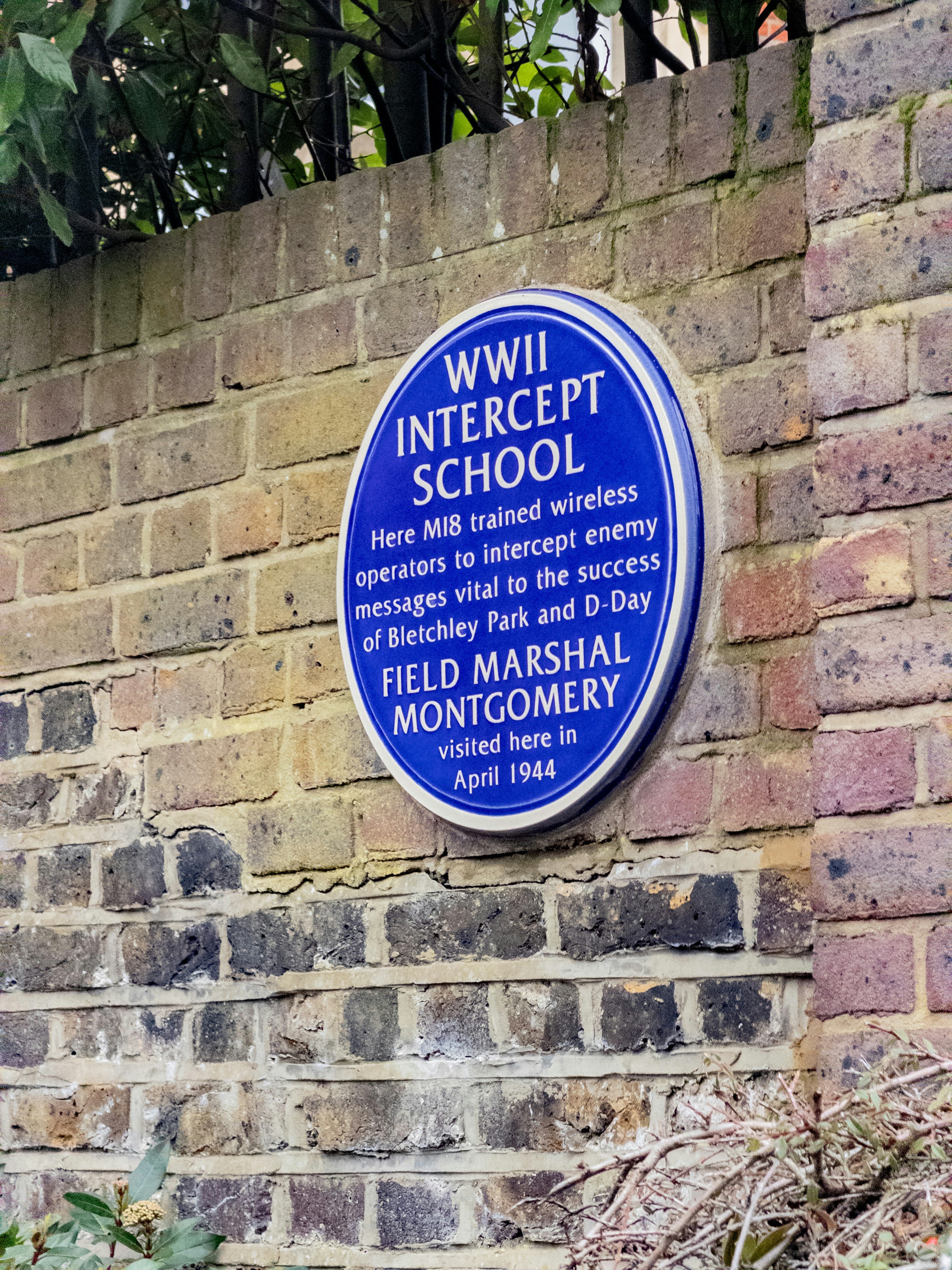 Blue Plaque on Weathered Brick Wall: WWII Intercept School