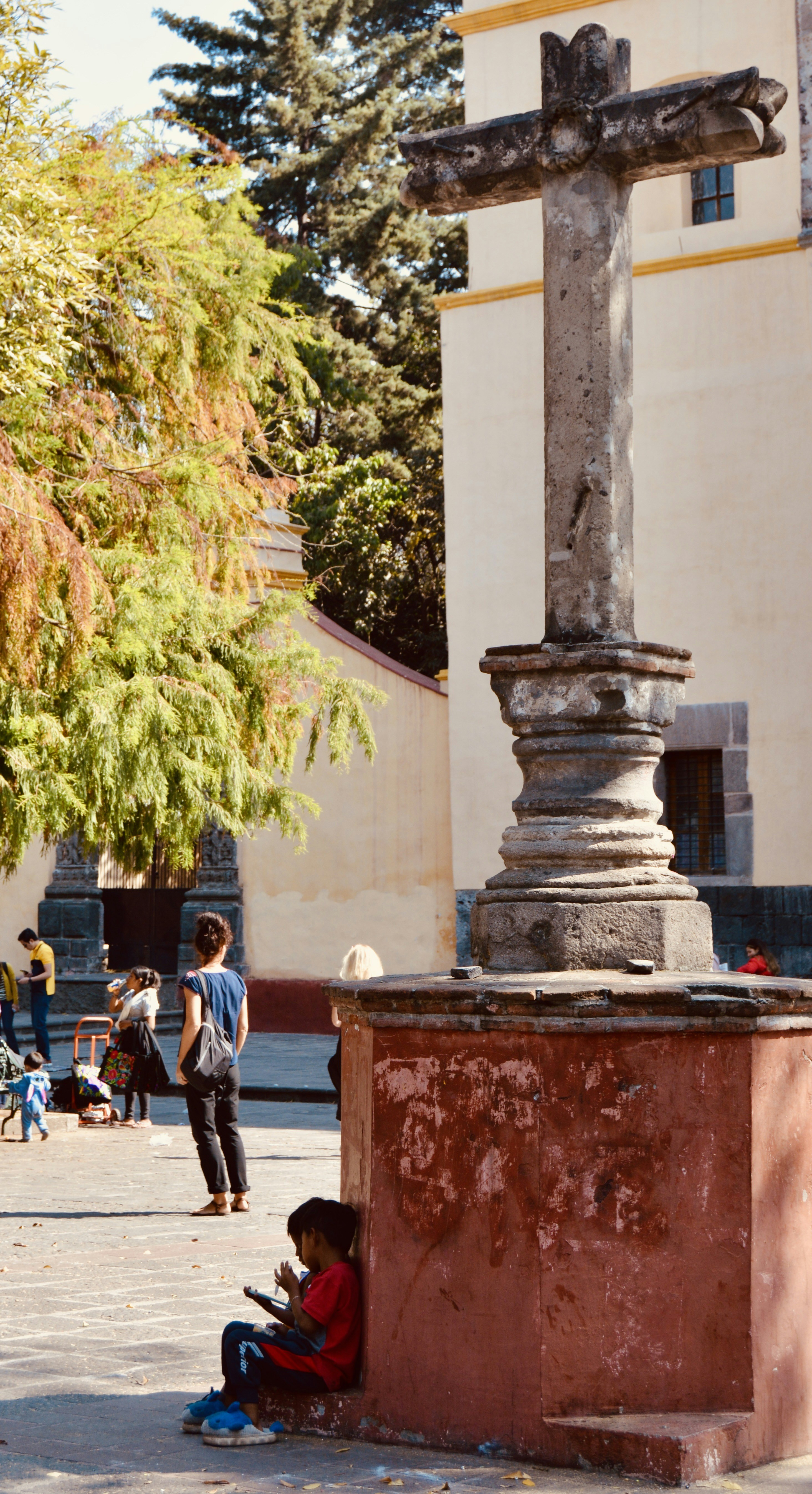 Stone Cross and Courtyard Quiet: A Moment by the Monument