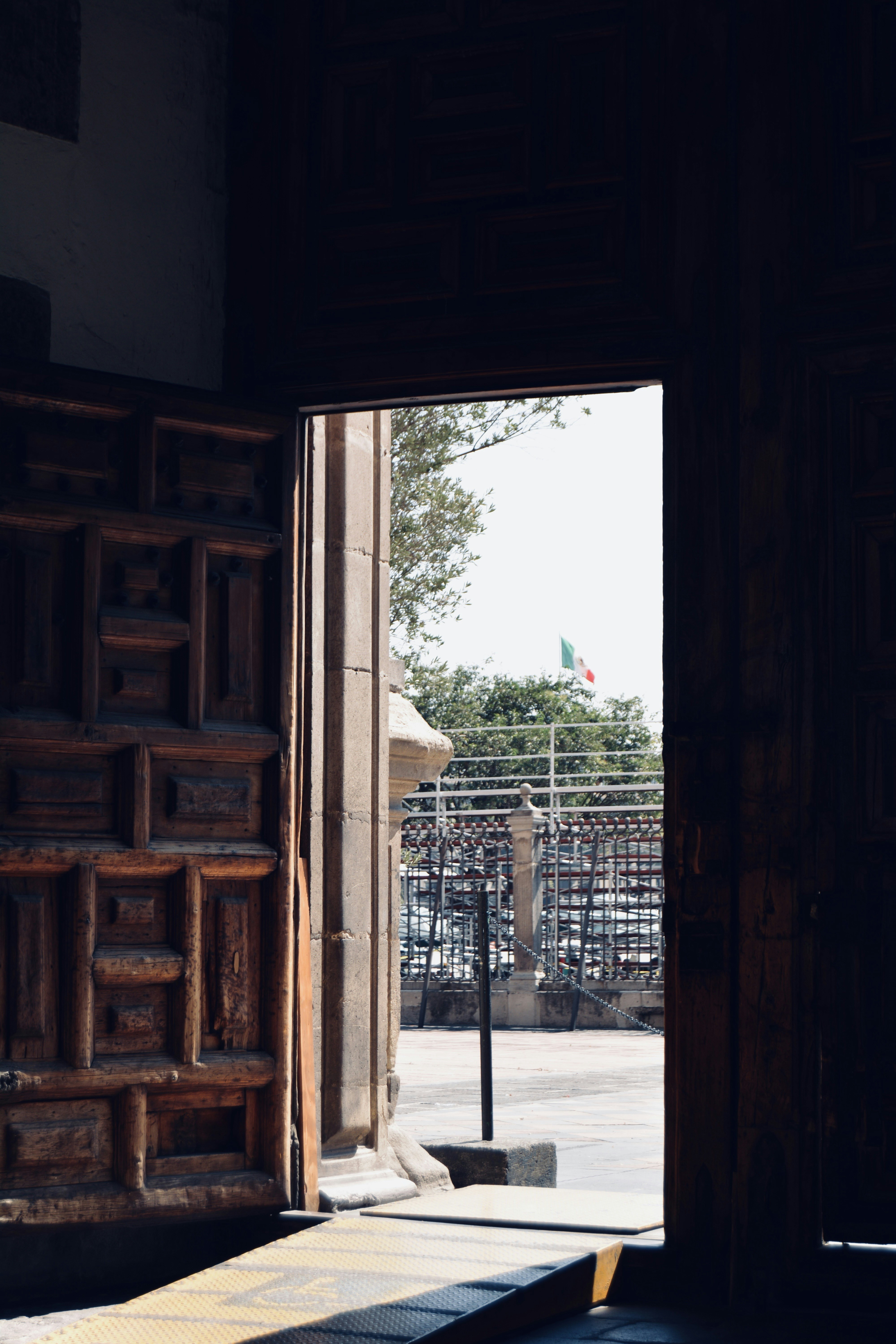 Threshold to the Outside: Light spilling from the doorway toward an orderly plaza