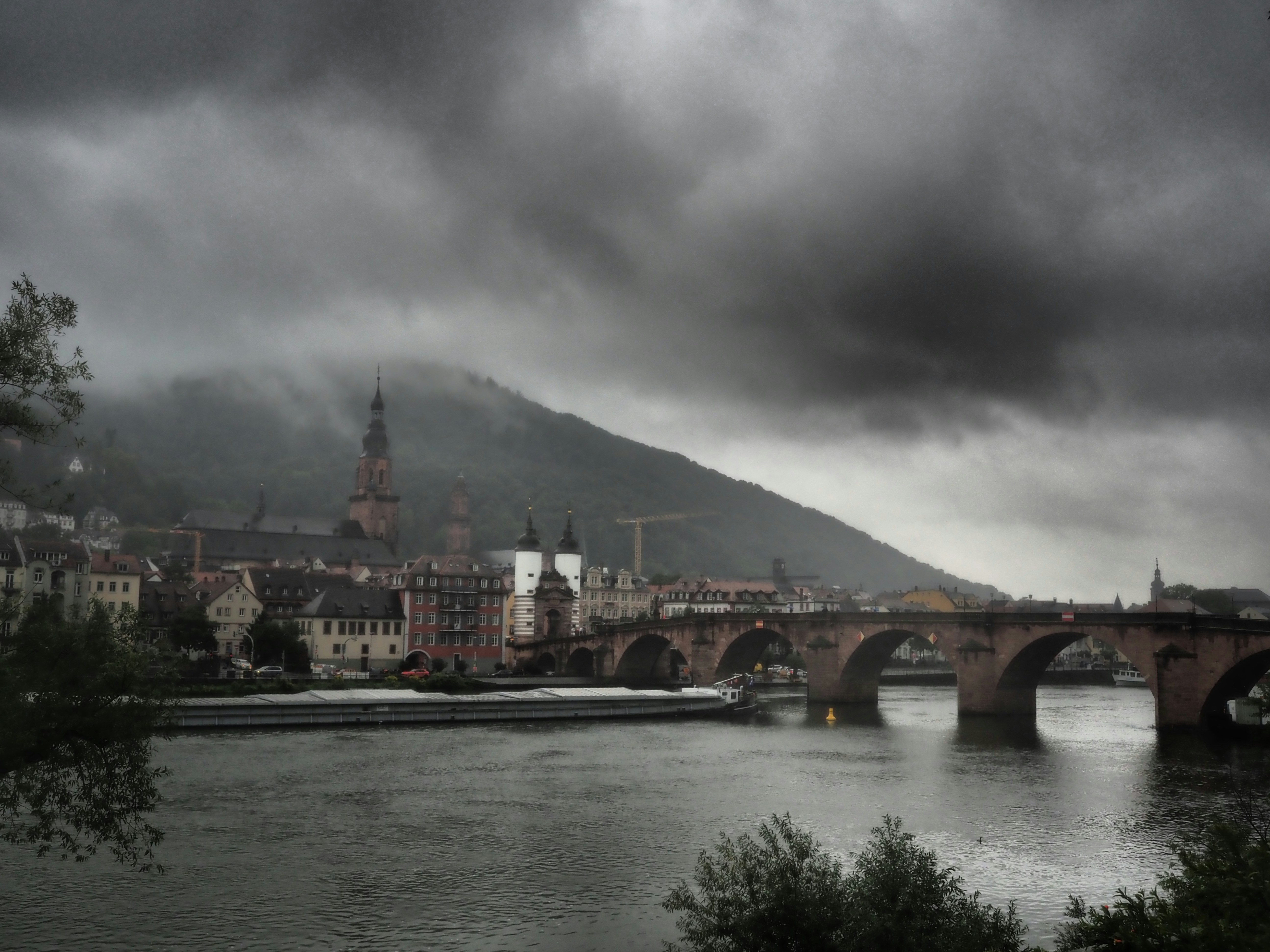 Storm over the Bridges: A Riverside Town Under Heavy Skies