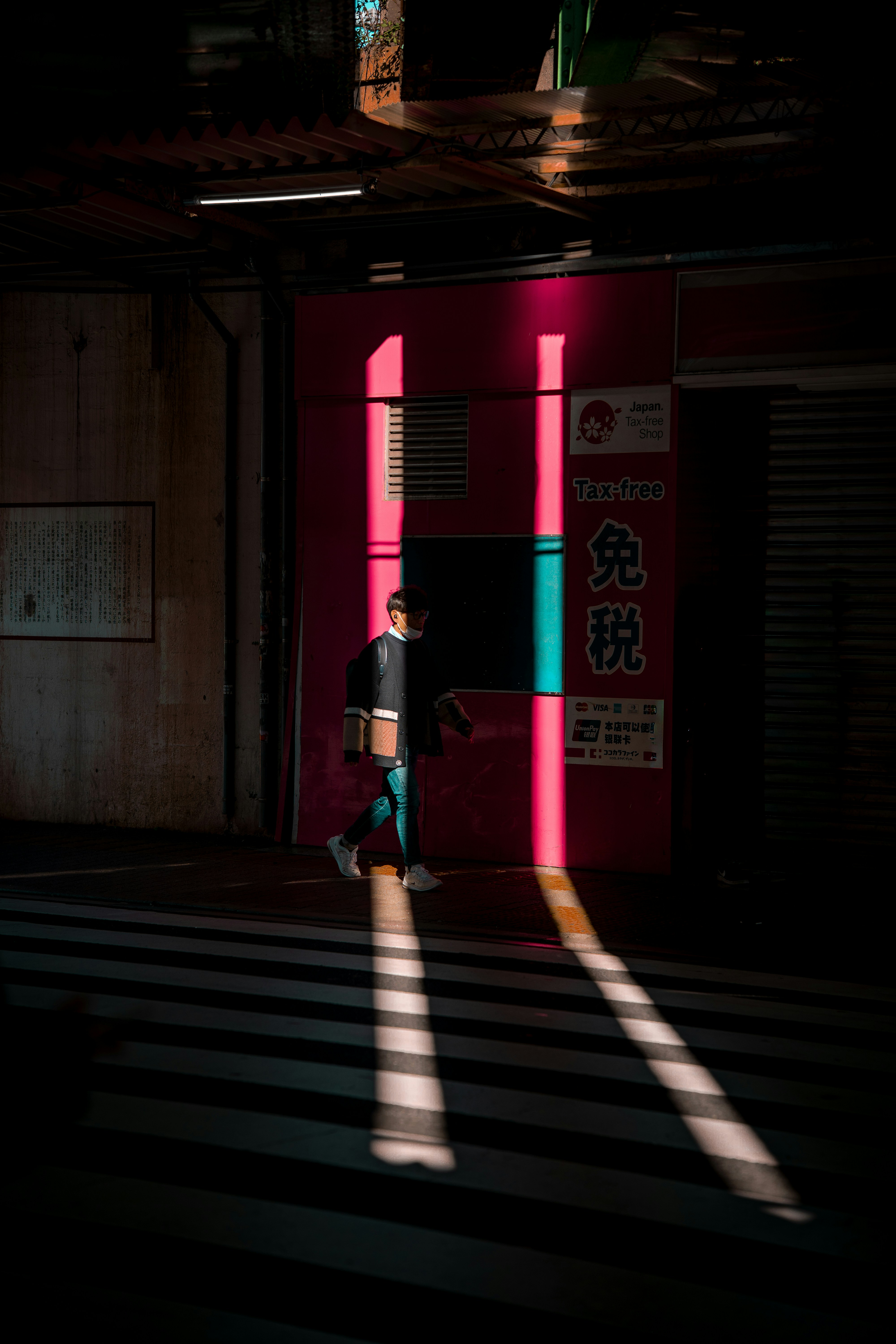Sunlit stride through a magenta storefront
