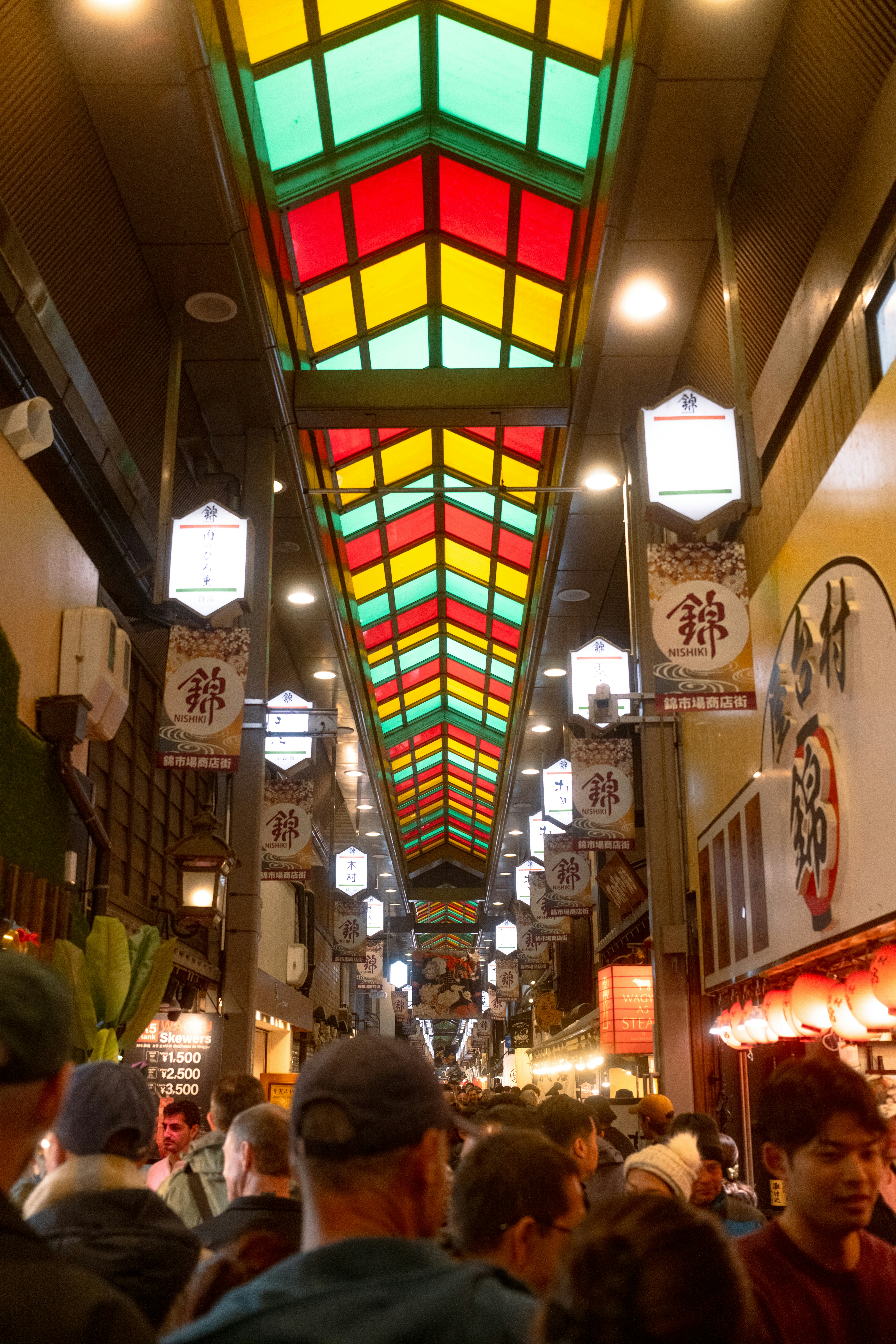 Colorful arcades: neon canopy leads the crowded market night