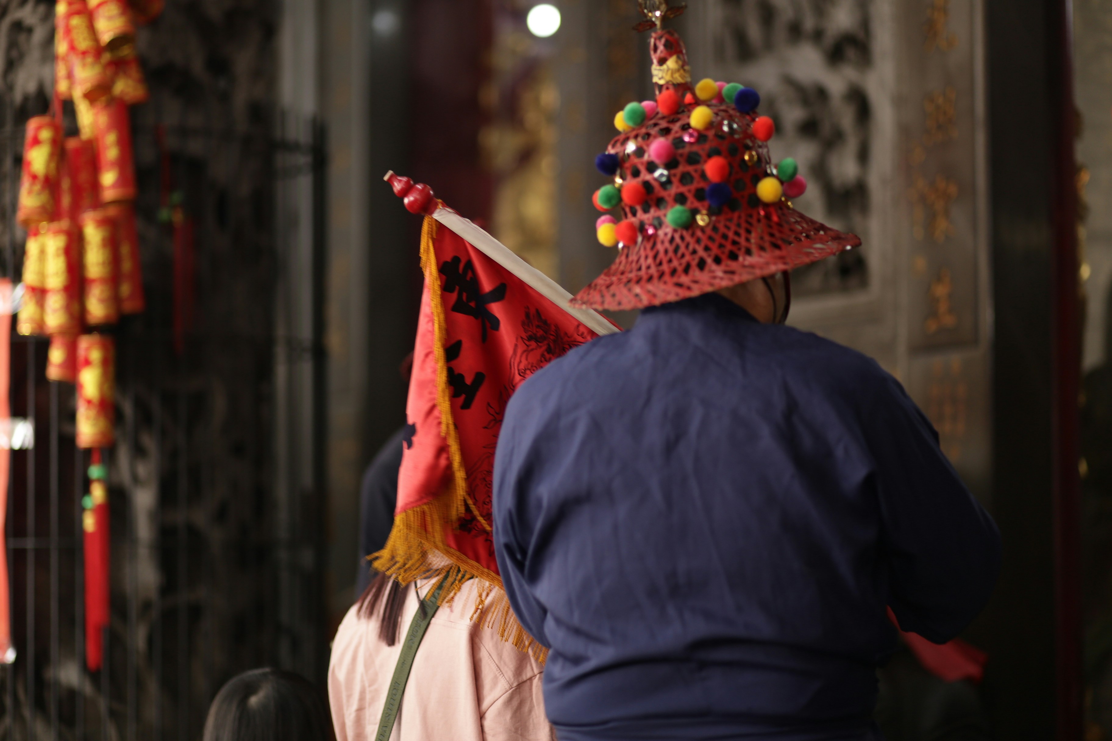 Colorful Hat in a Dim Market: Hidden Faces, Vibrant Craft
