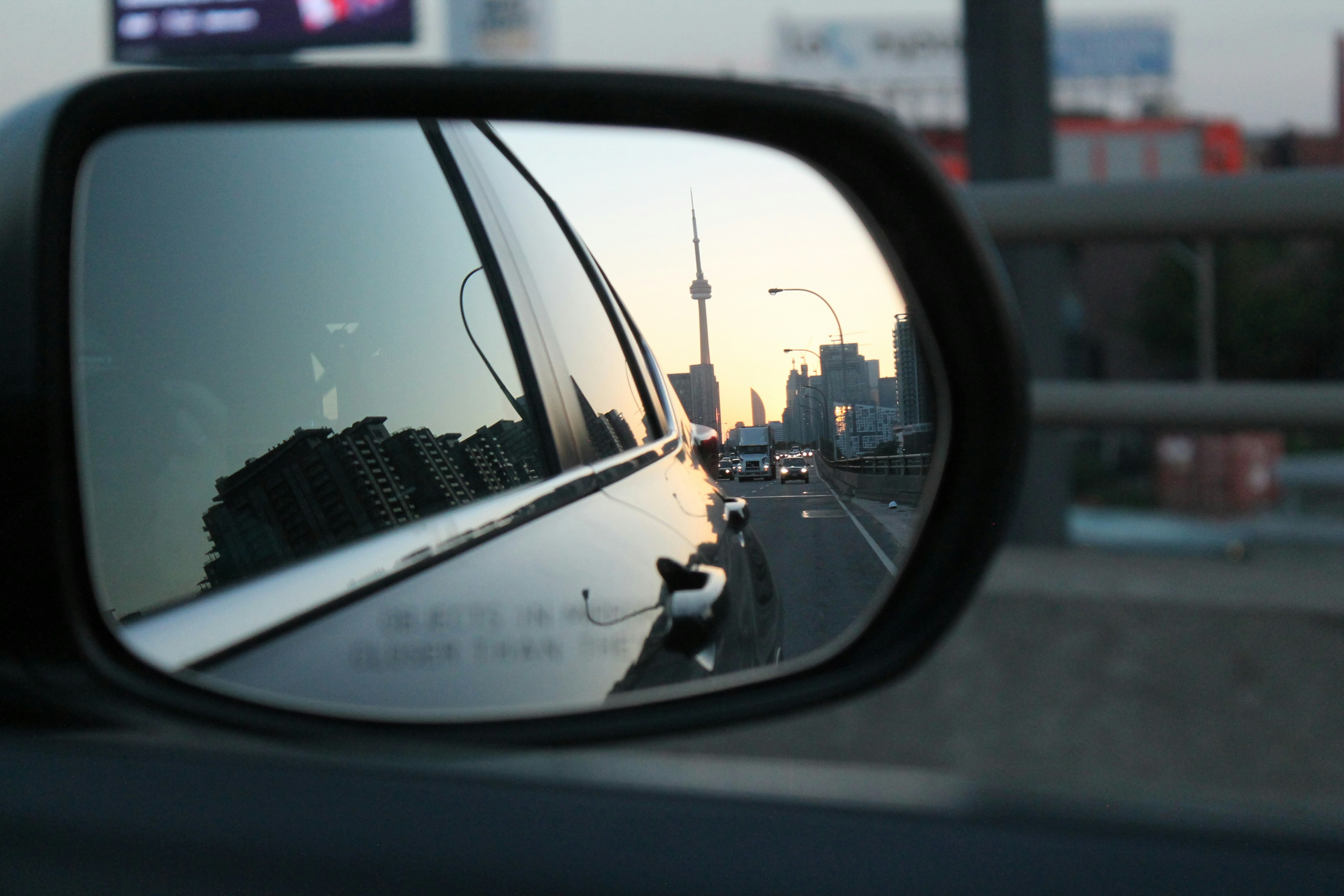 City in the Mirror: Skyline Reflected in a Car's Side View