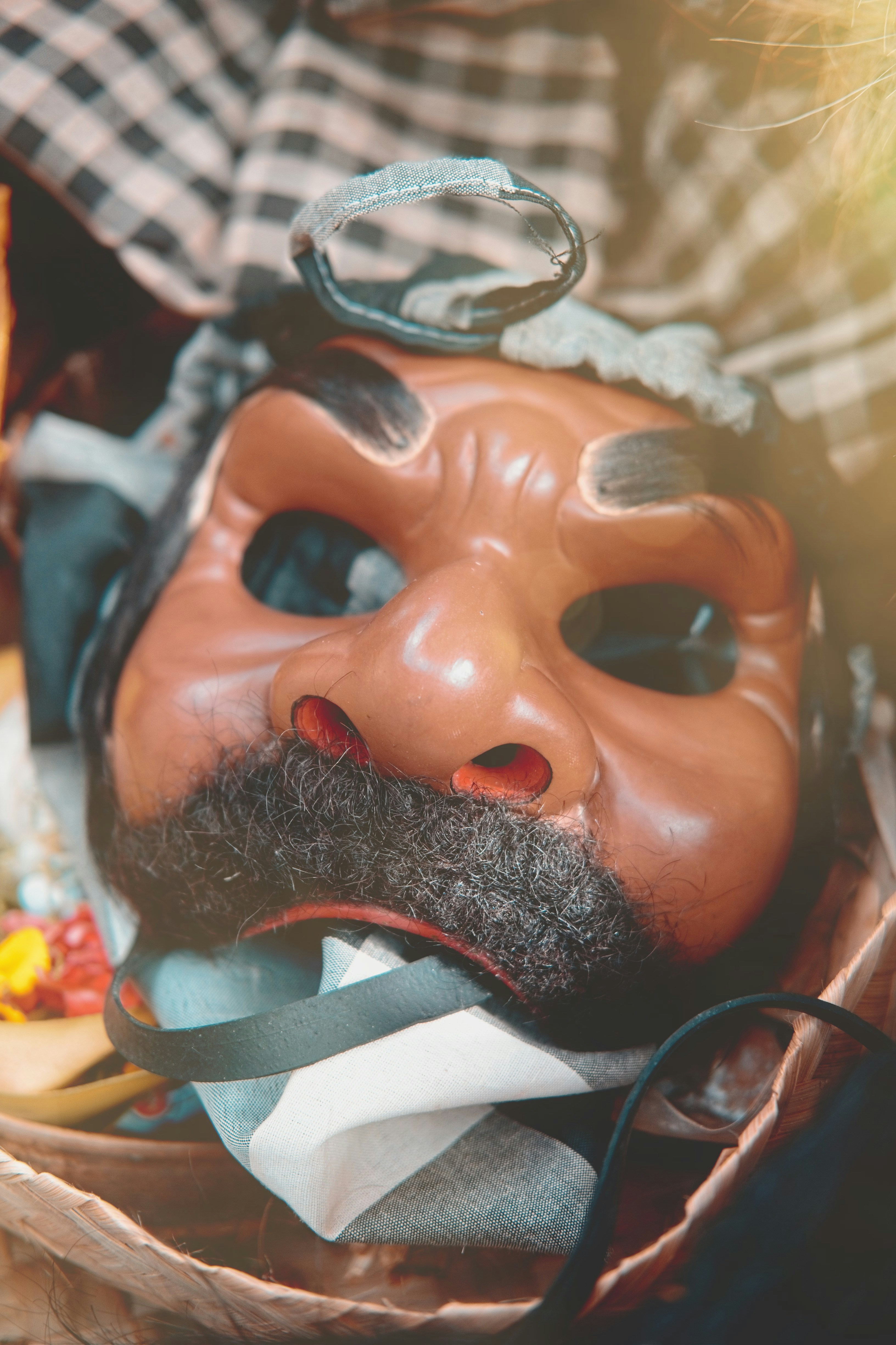 Masked Gaze: Theatrical Face Amid Vintage Props