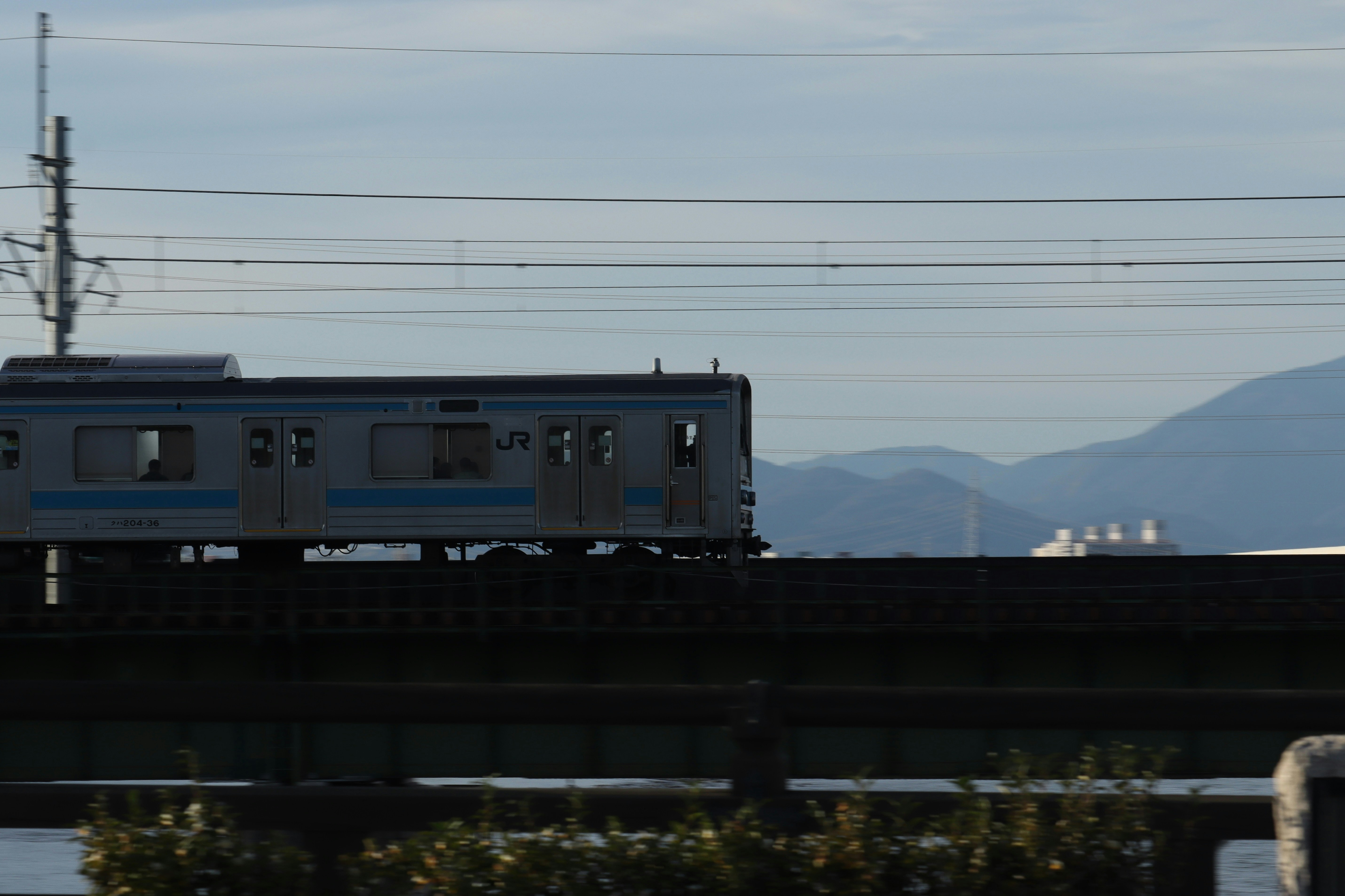 Lonely Rail Runner: A Blue Commuter Crossing the Skyline