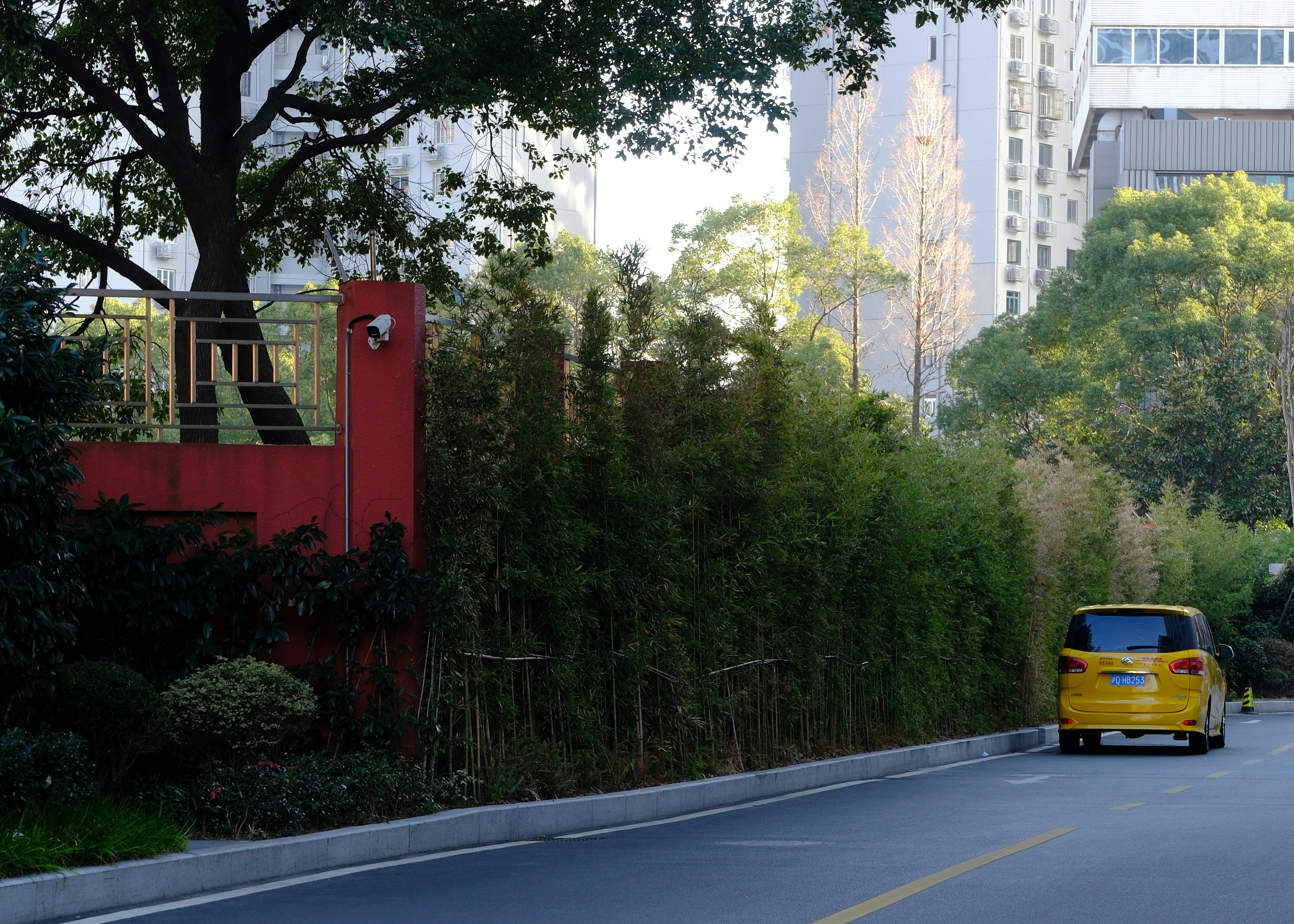 Yellow Taxi on a Quiet Urban Road Surrounded by Greenery