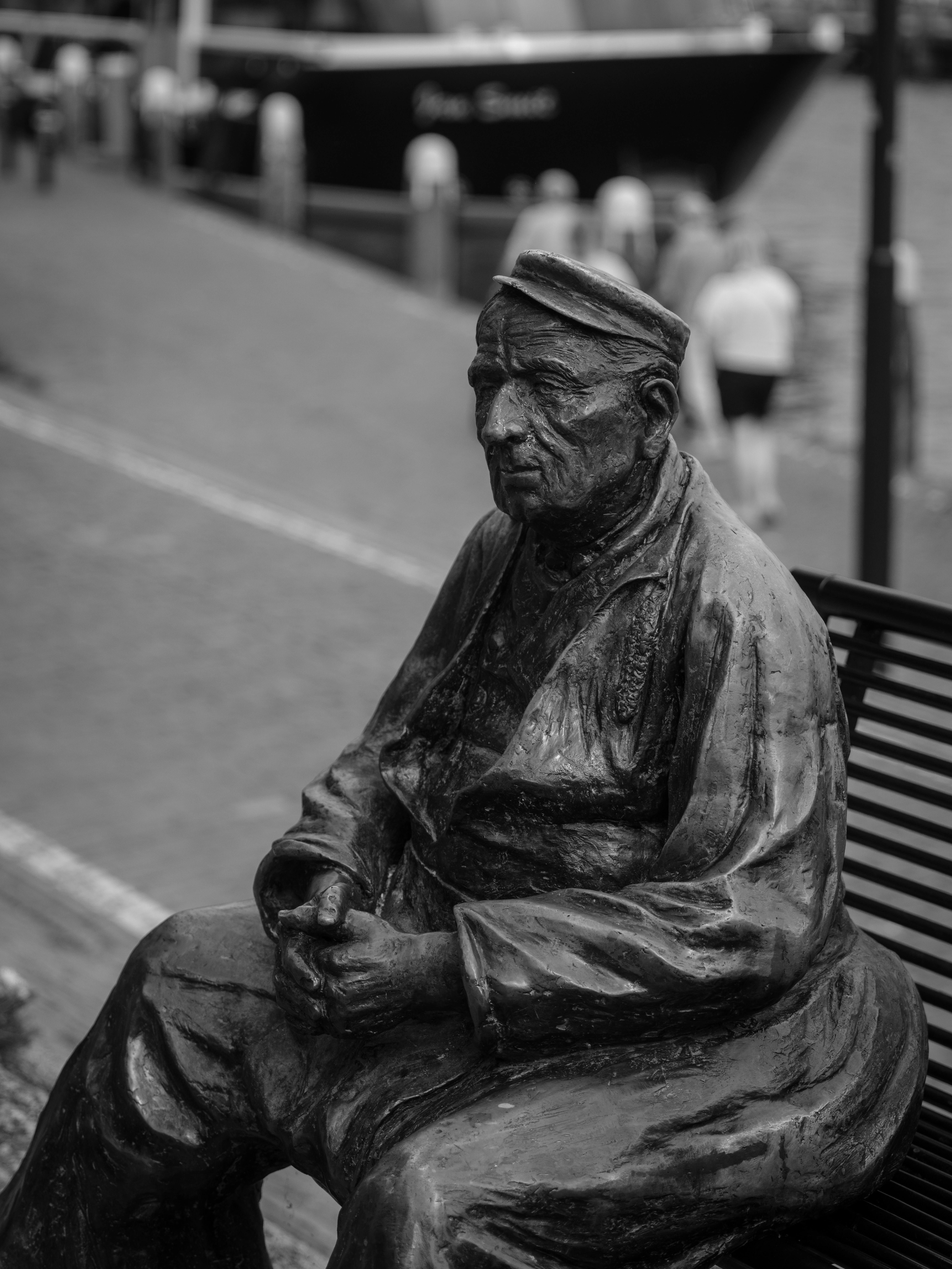 Harbor-side Sage: A Weathered Seated Figure in Bronze