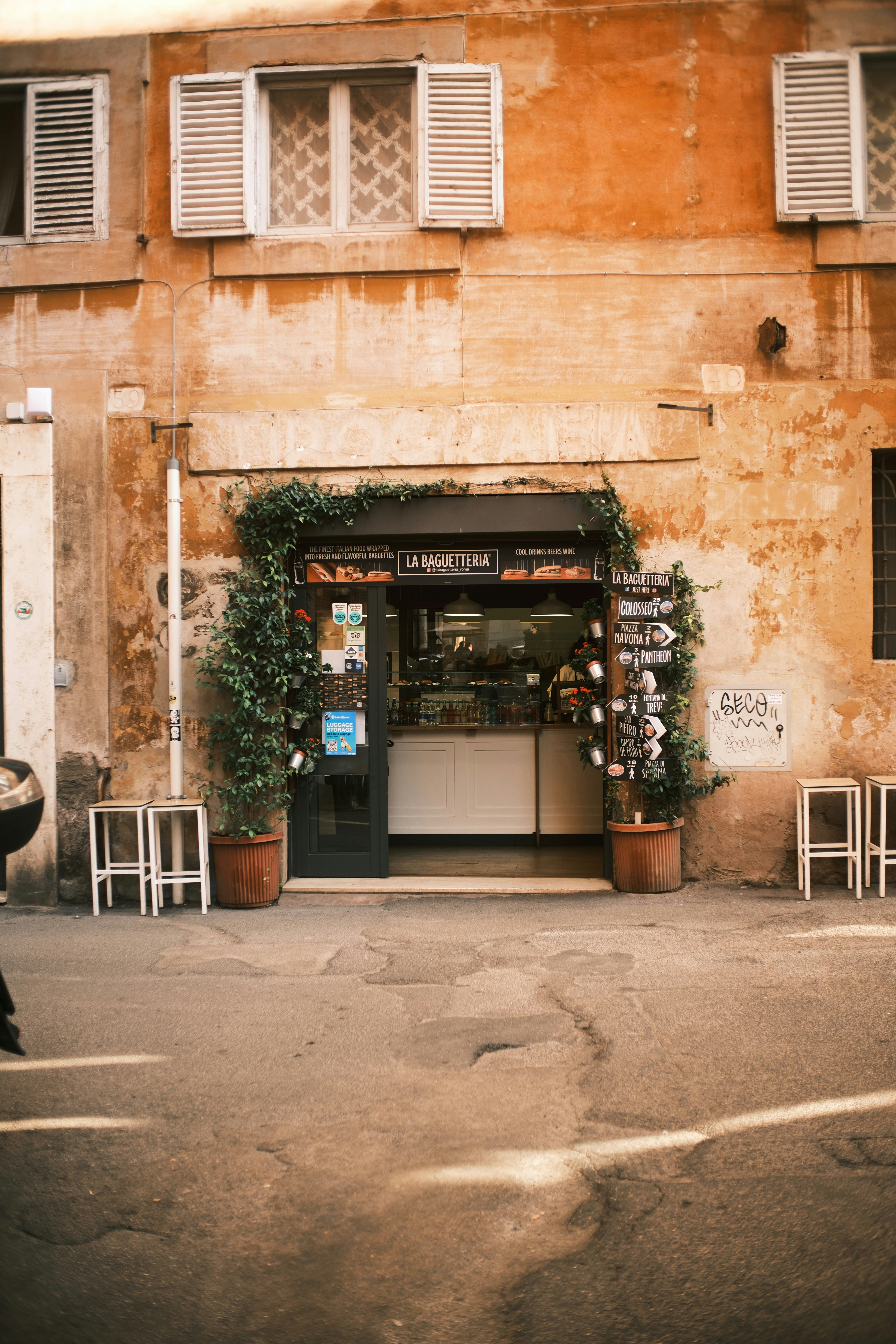 Sunlit Bistro Gateway: A Warm Italian Facade Framed by Green Vines
