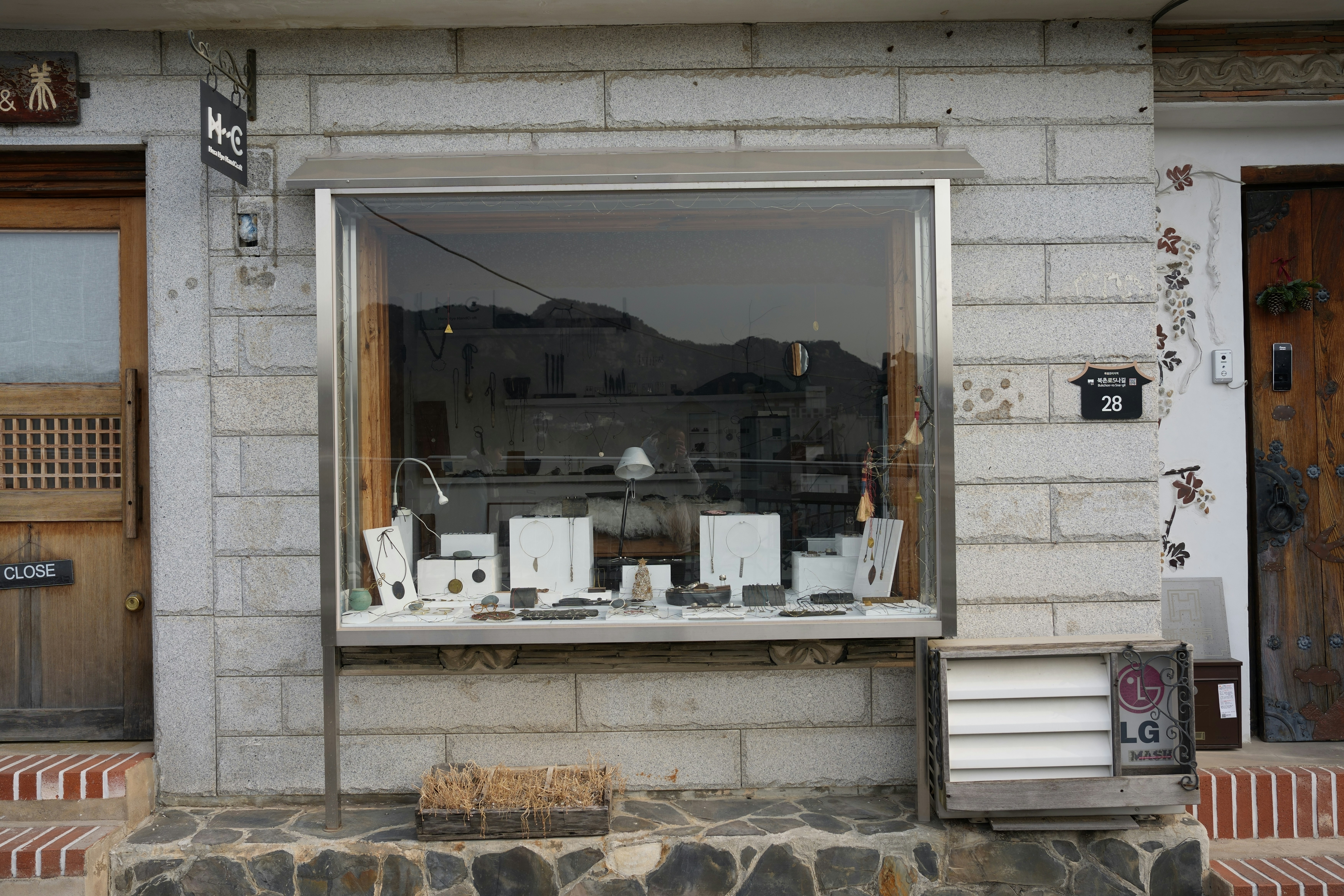 Shop Window Portrait: A Quiet Display of Brushed Metal and Ceramic in a Stone Facade
