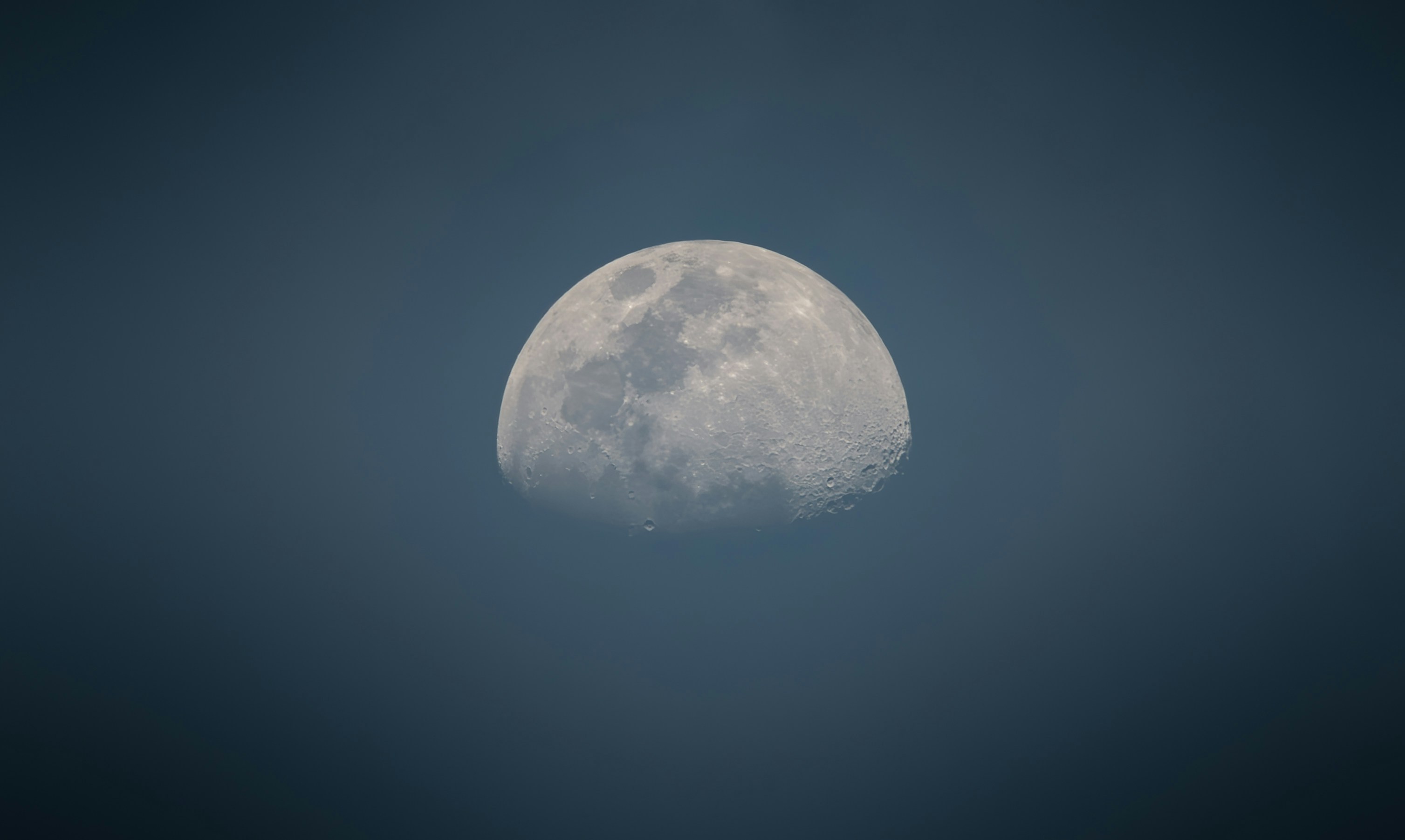 Lone Moon afloat in a midnight blue hush