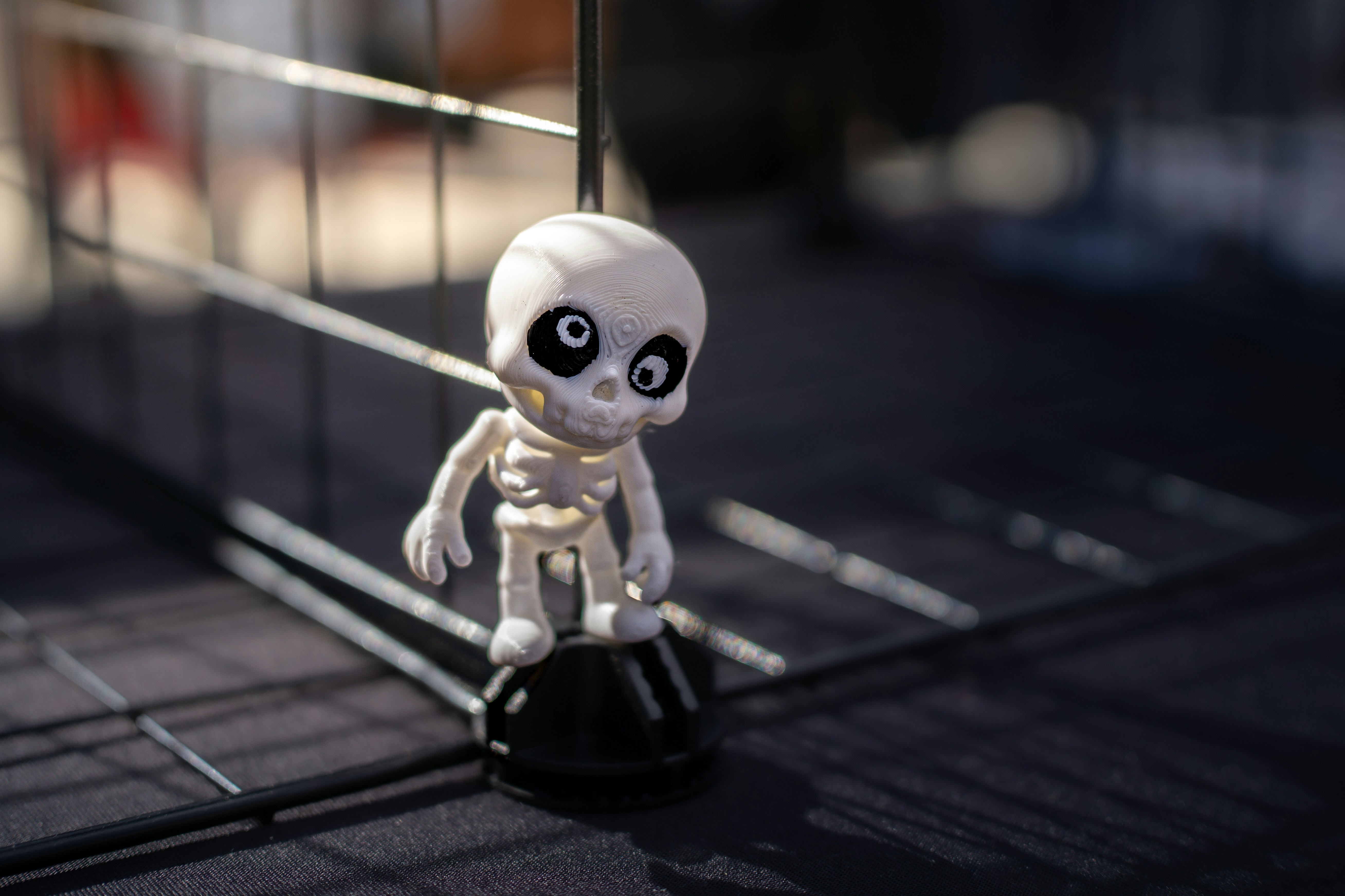 Tiny Skeleton of Light: A Toy Figure in Focus on a Shadowed Stage