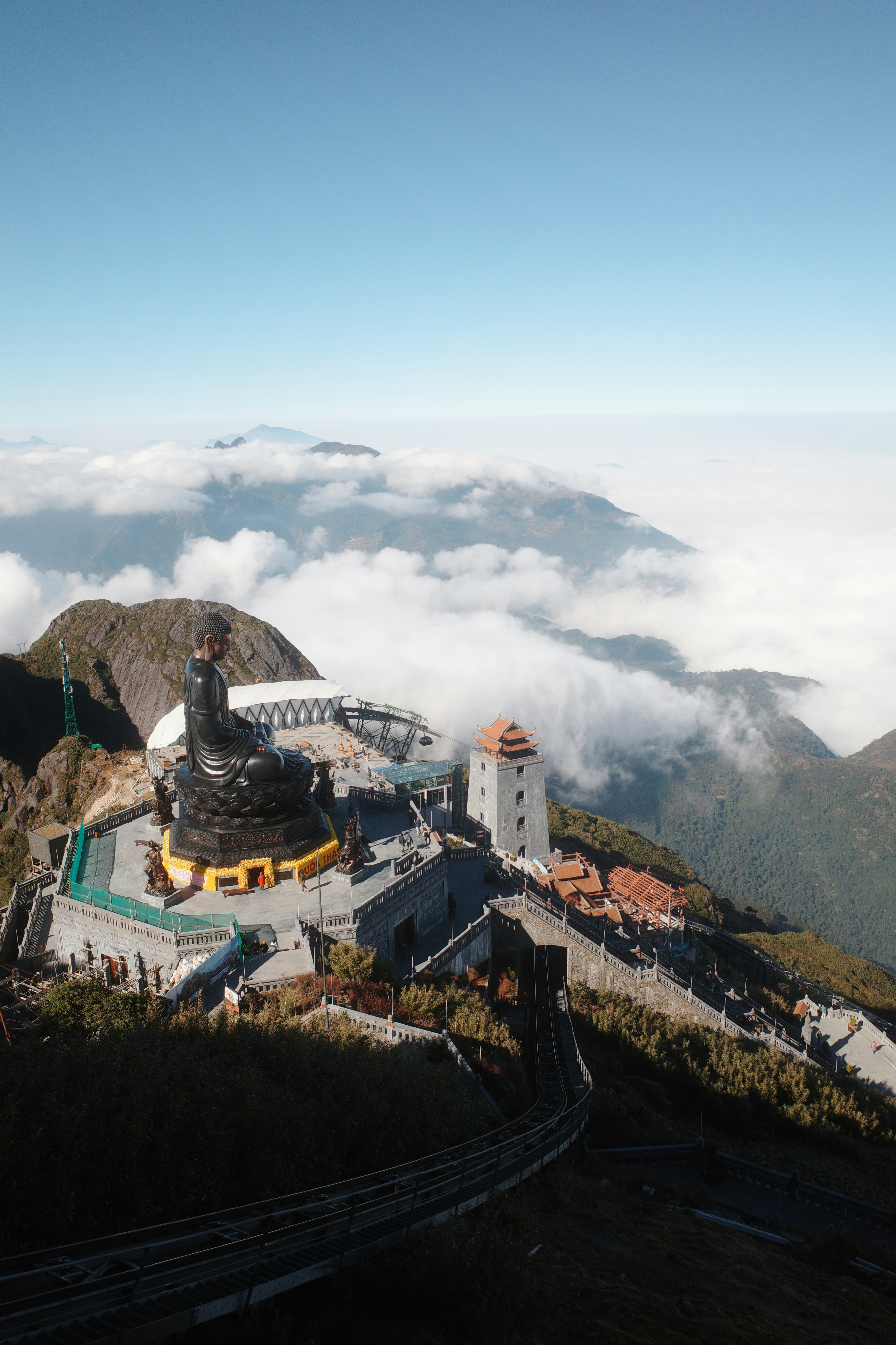 Sacred Summit: A Buddha overlooking sea of clouds from a coastal cliff temple
