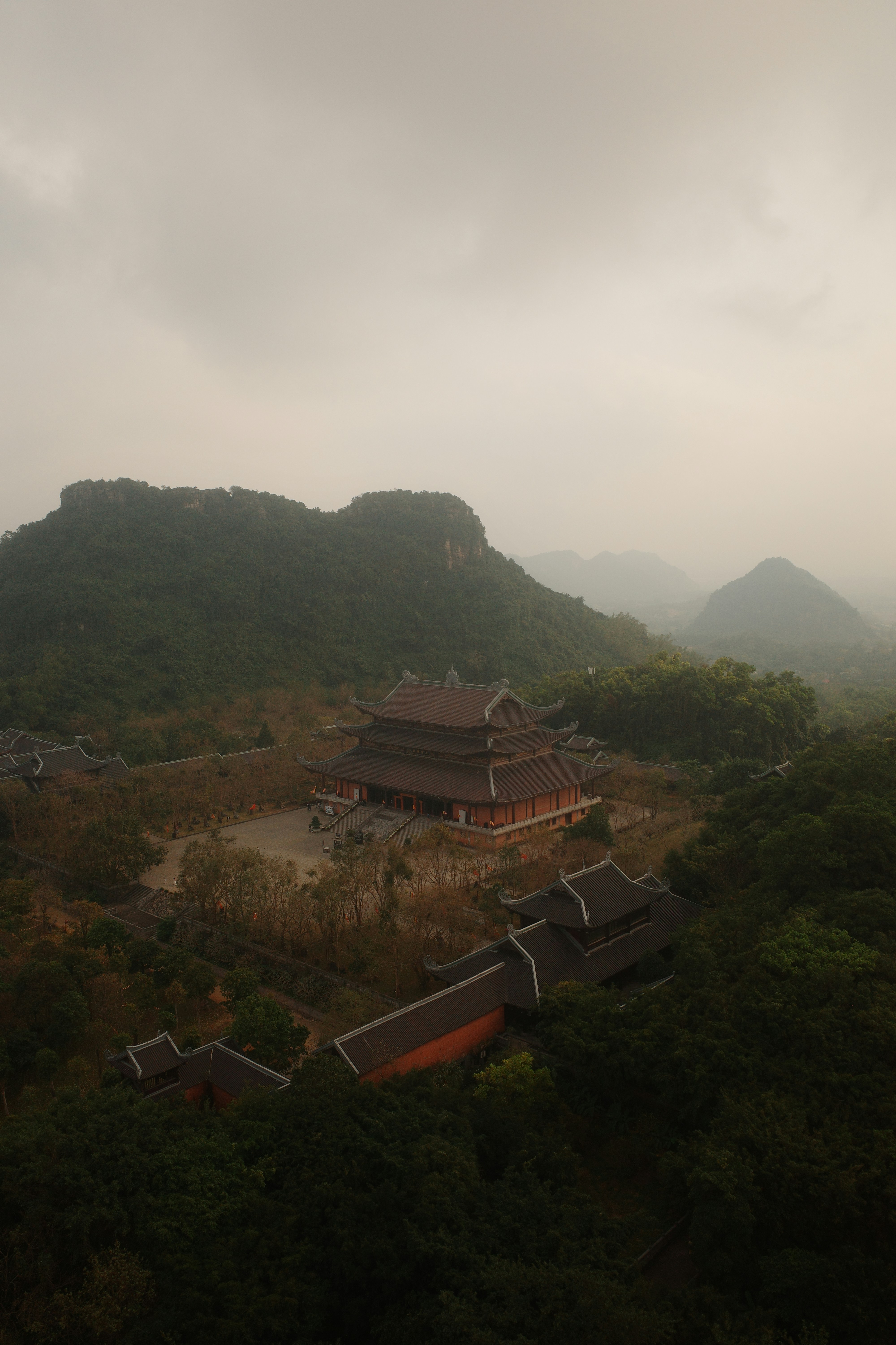 Temple in the Mist: A Terraced Complex Nestled Among Pale Hills